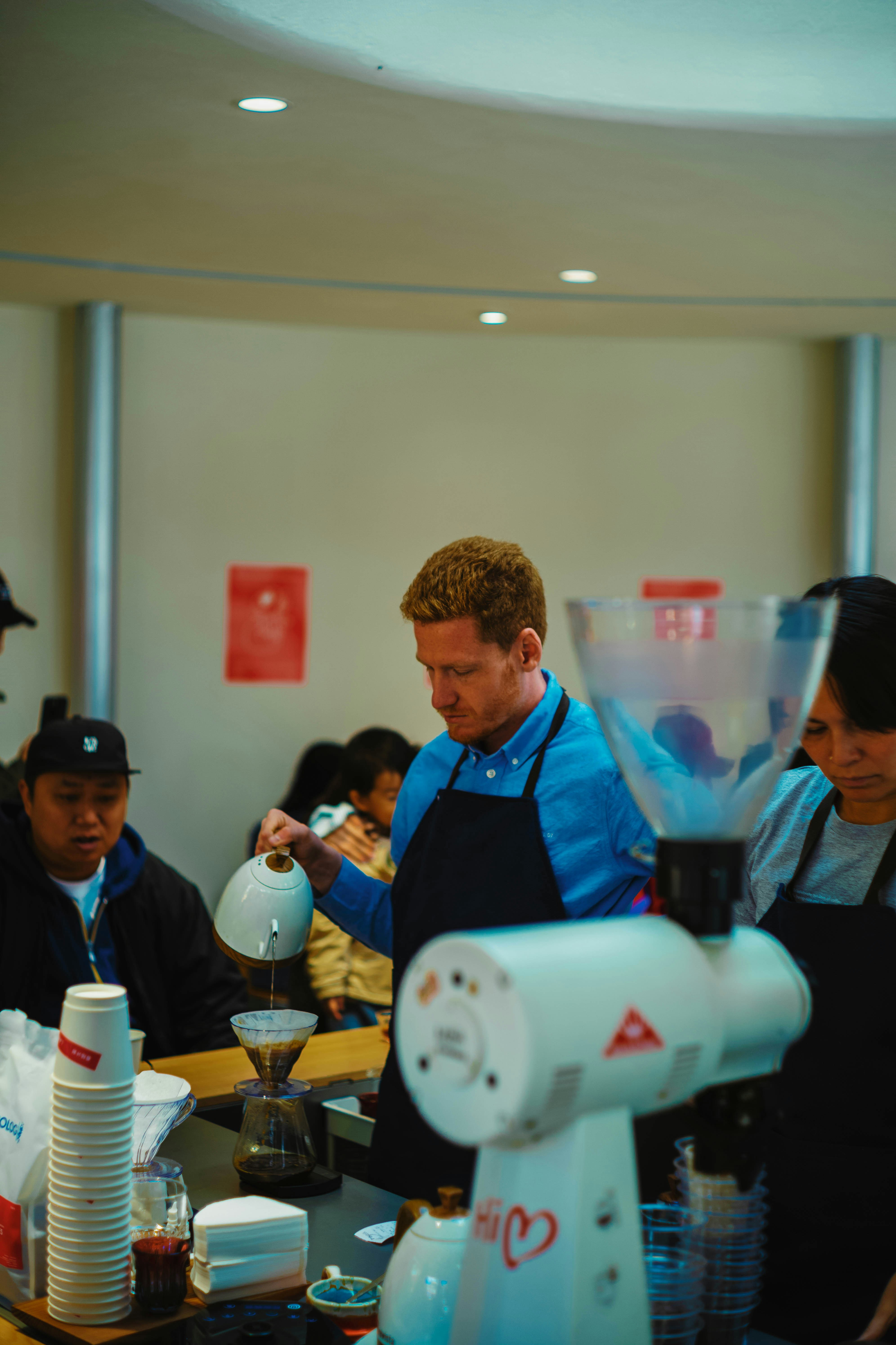 Pour-over Focus: Barista at the Center of a Busy Café