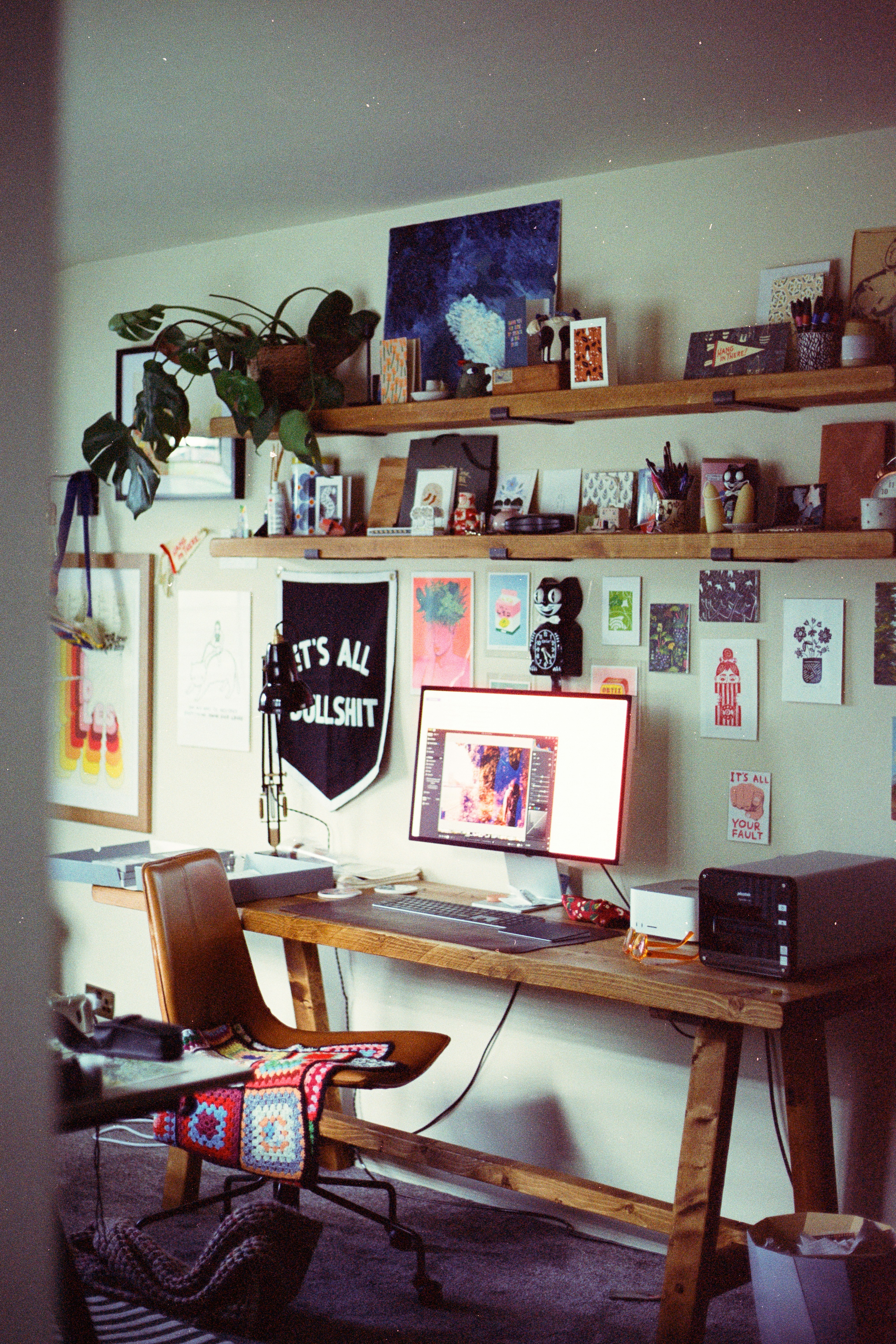 A cluttered desk with a computer and art supplies.