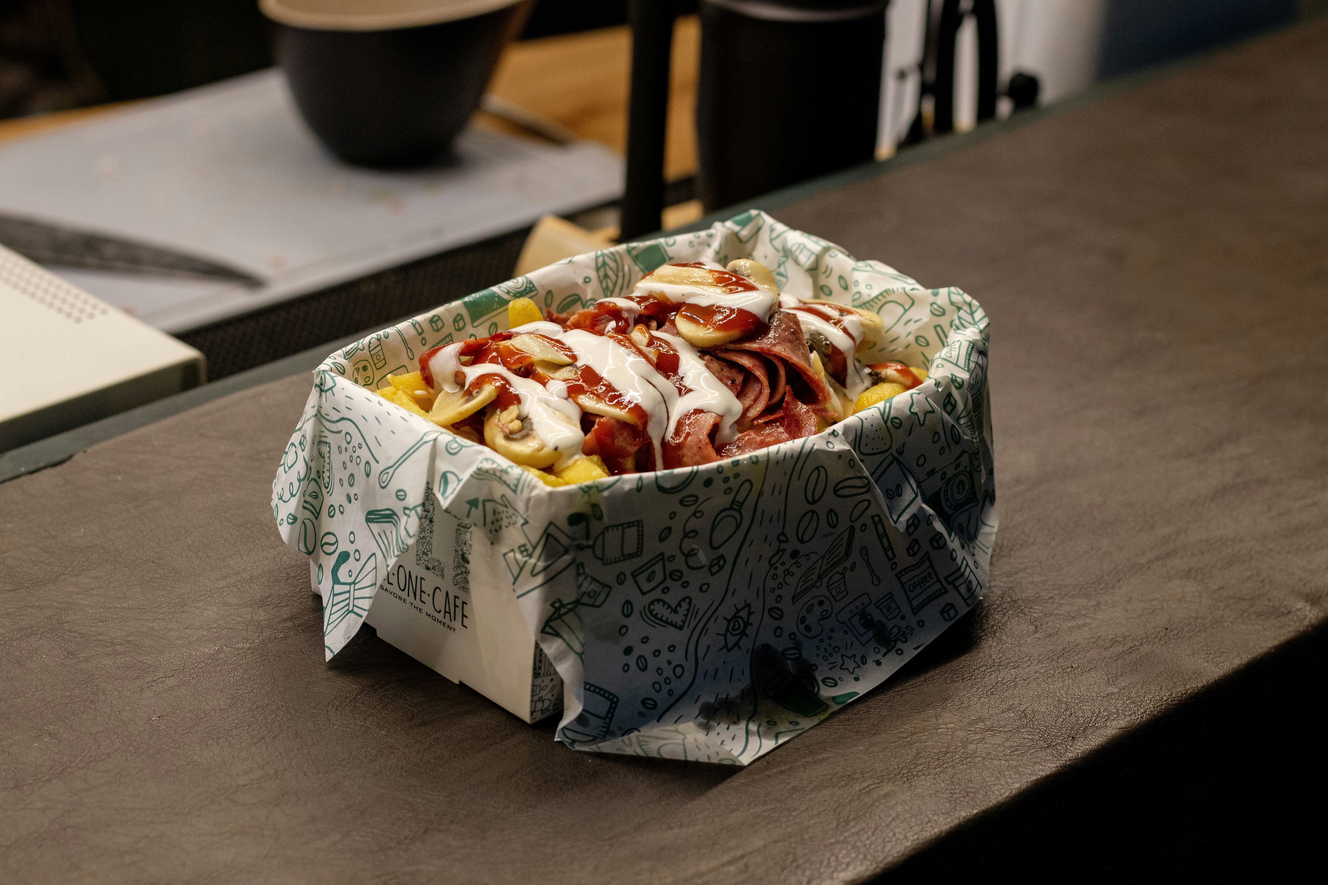 Caramel-Topped Pastry Nestled in a Patterned Paper Basket on a Quiet Café Counter