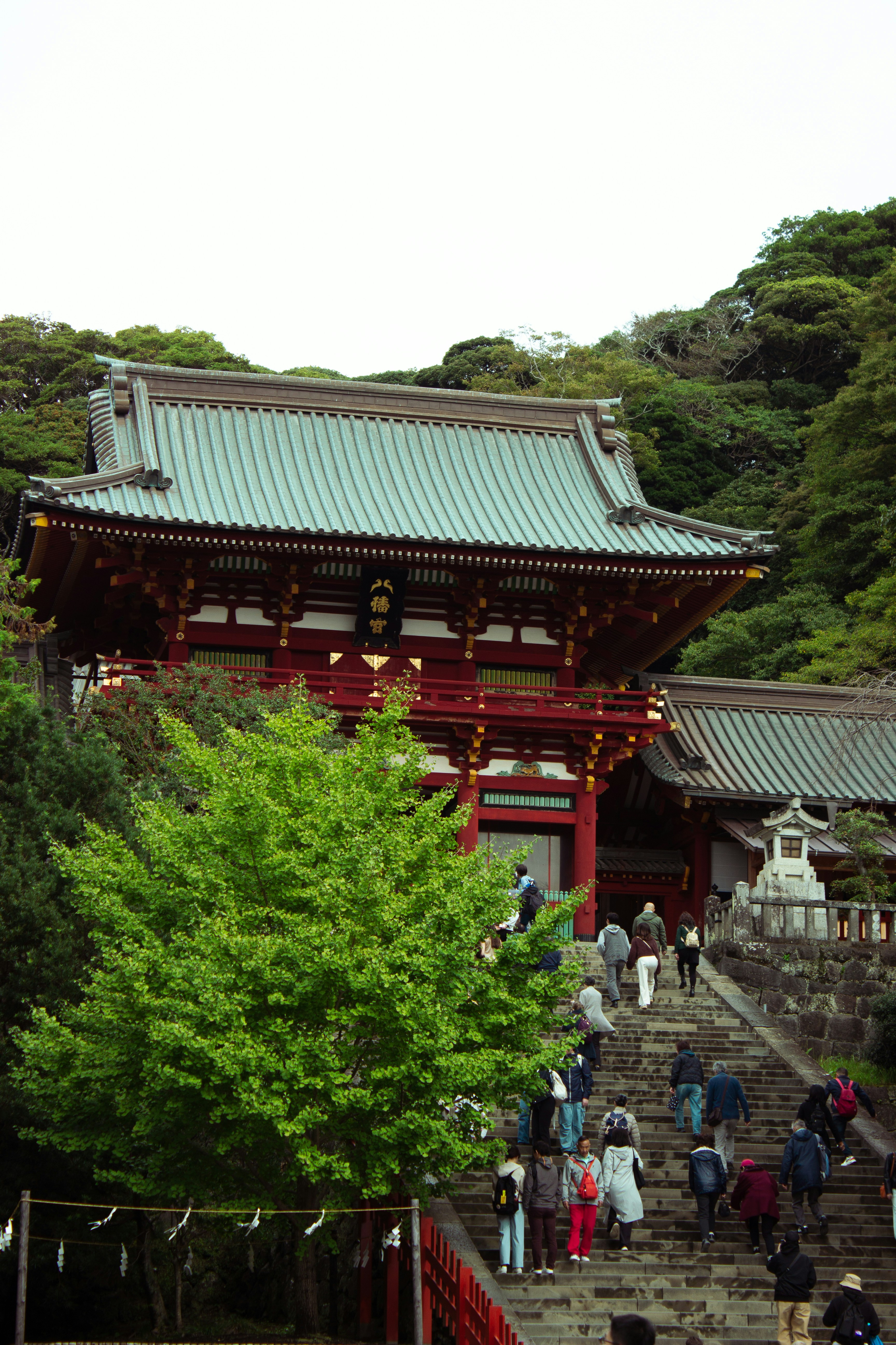 People climbing stairs towards a japanese temple entrance gate photo ...