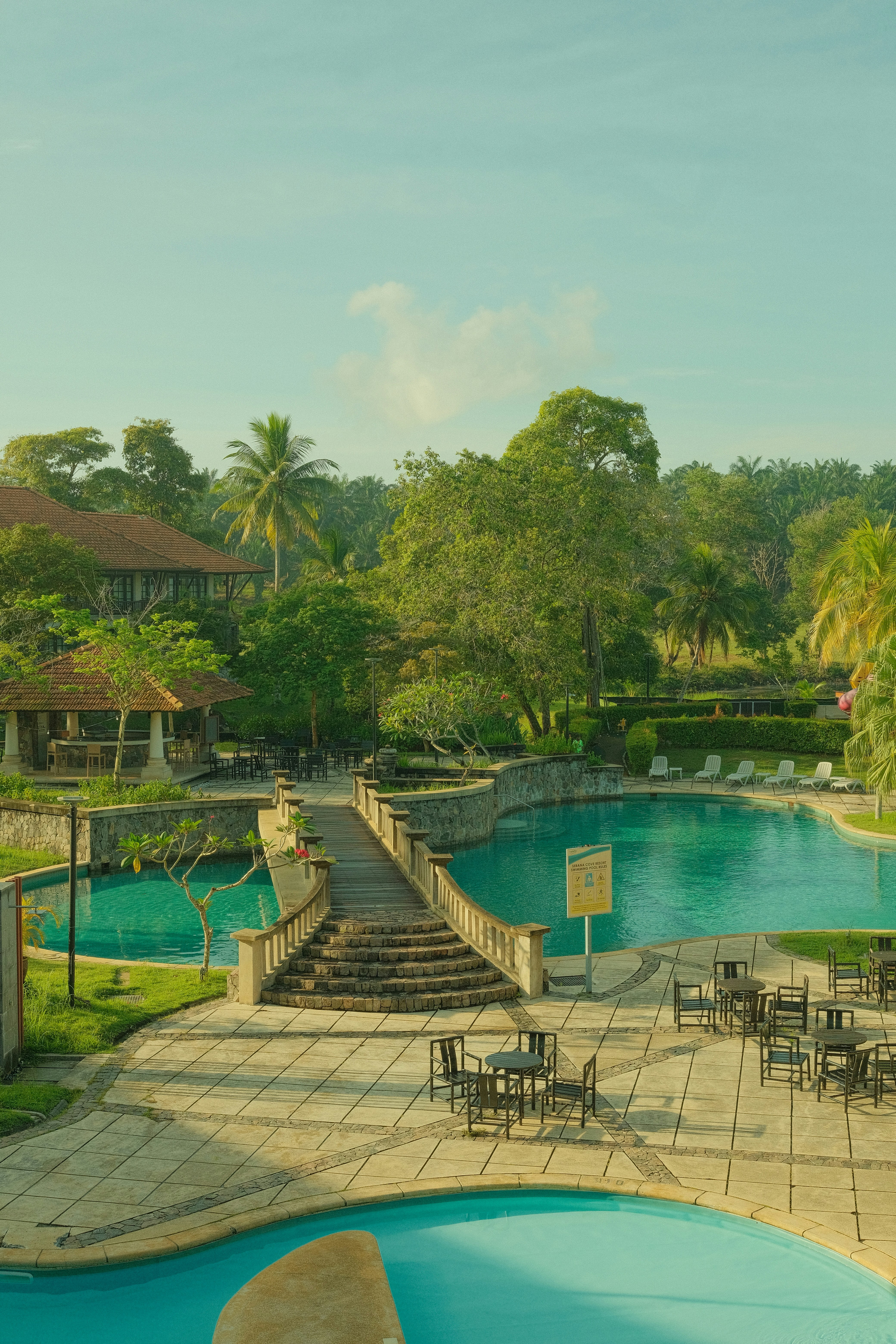 Stone-Bridge Oasis: Palm-Lined Pools Thread Across a Terraced Tropical Resort