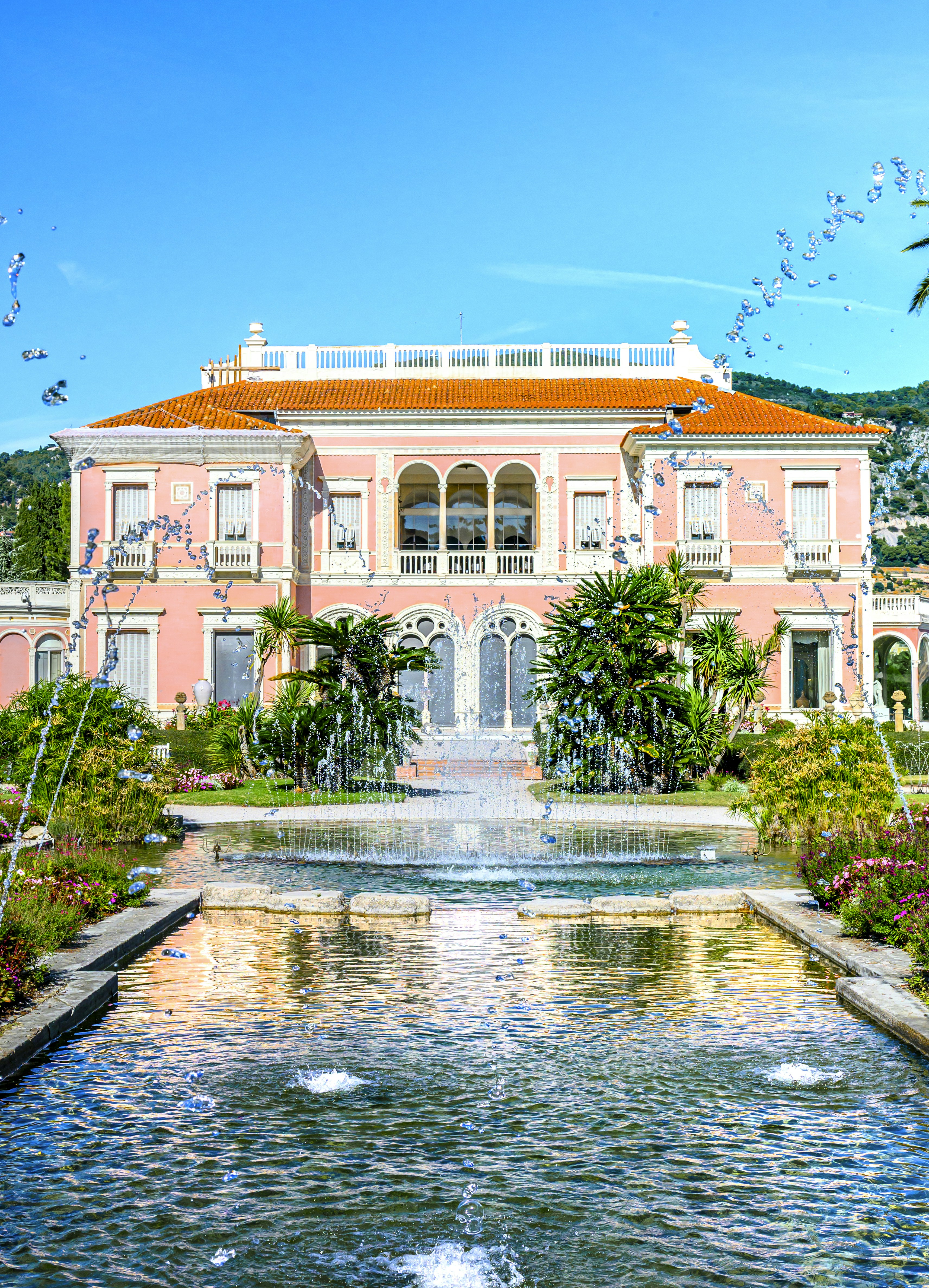 Pink Mediterranean Villa Framed by a Reflective Garden Canal