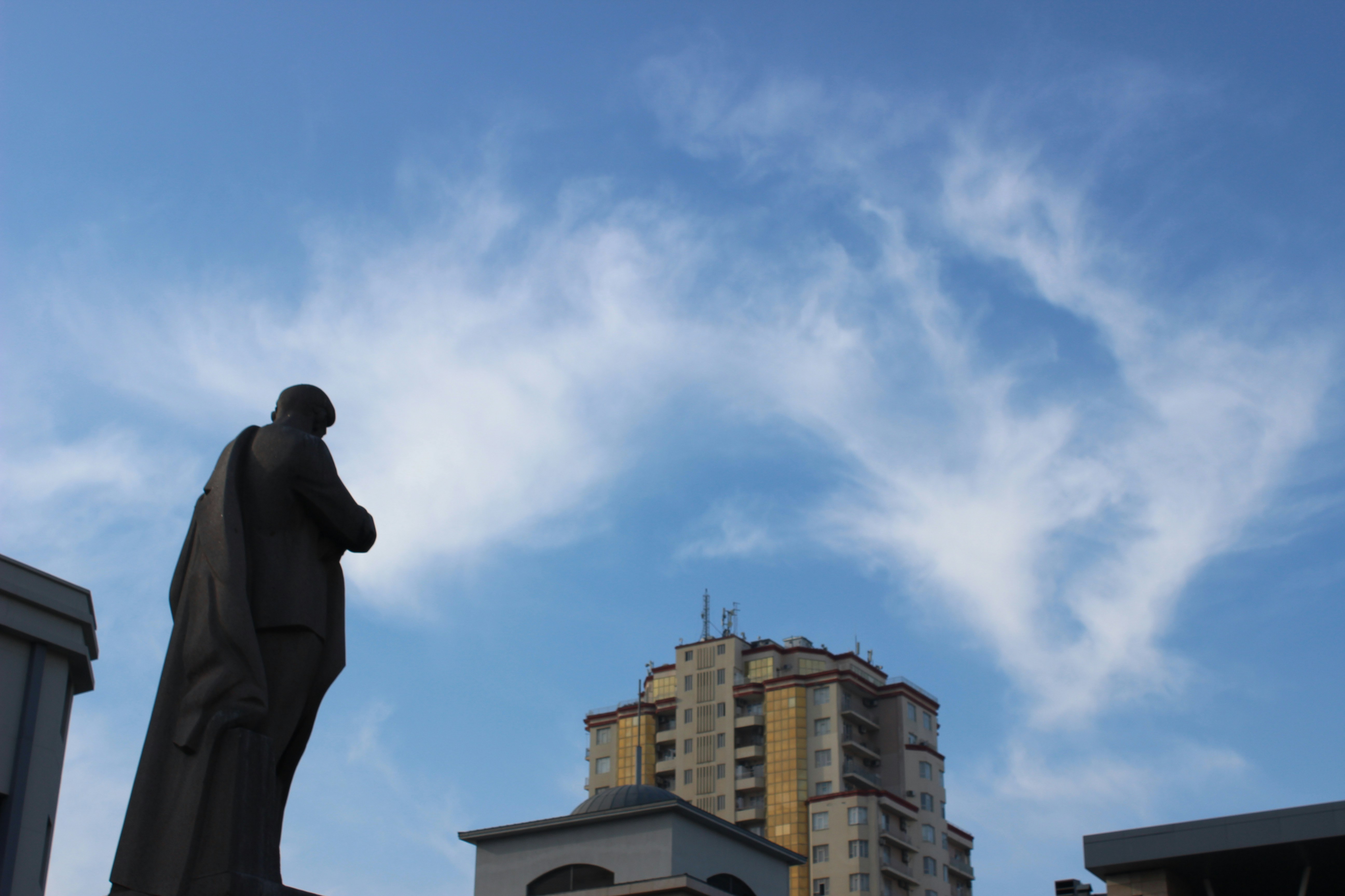 A Quiet Silhouette: Statue and Sky Beneath a City Prism