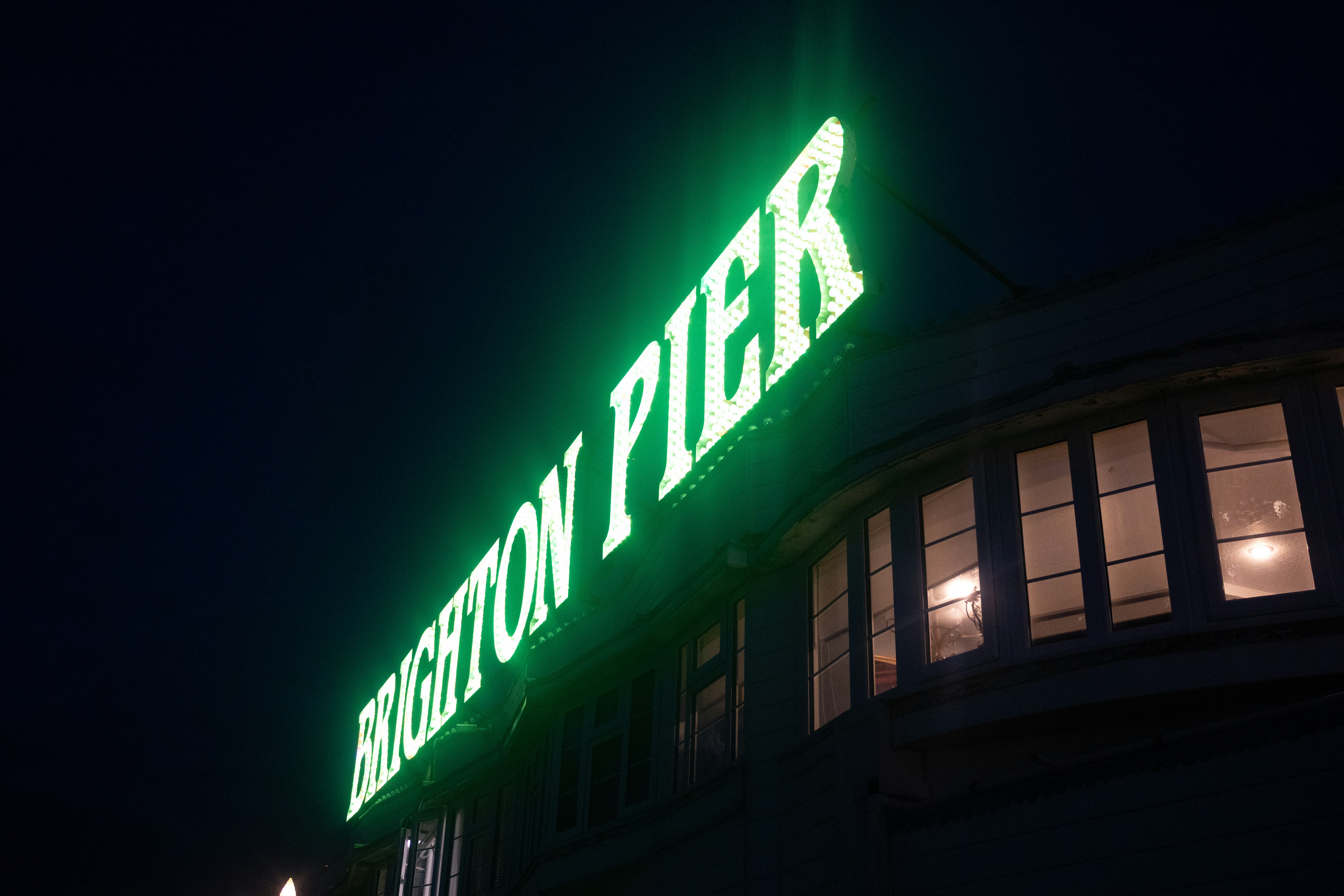 Neon Beacon Over Brighton Pier: Night Sign in Emerald Glow