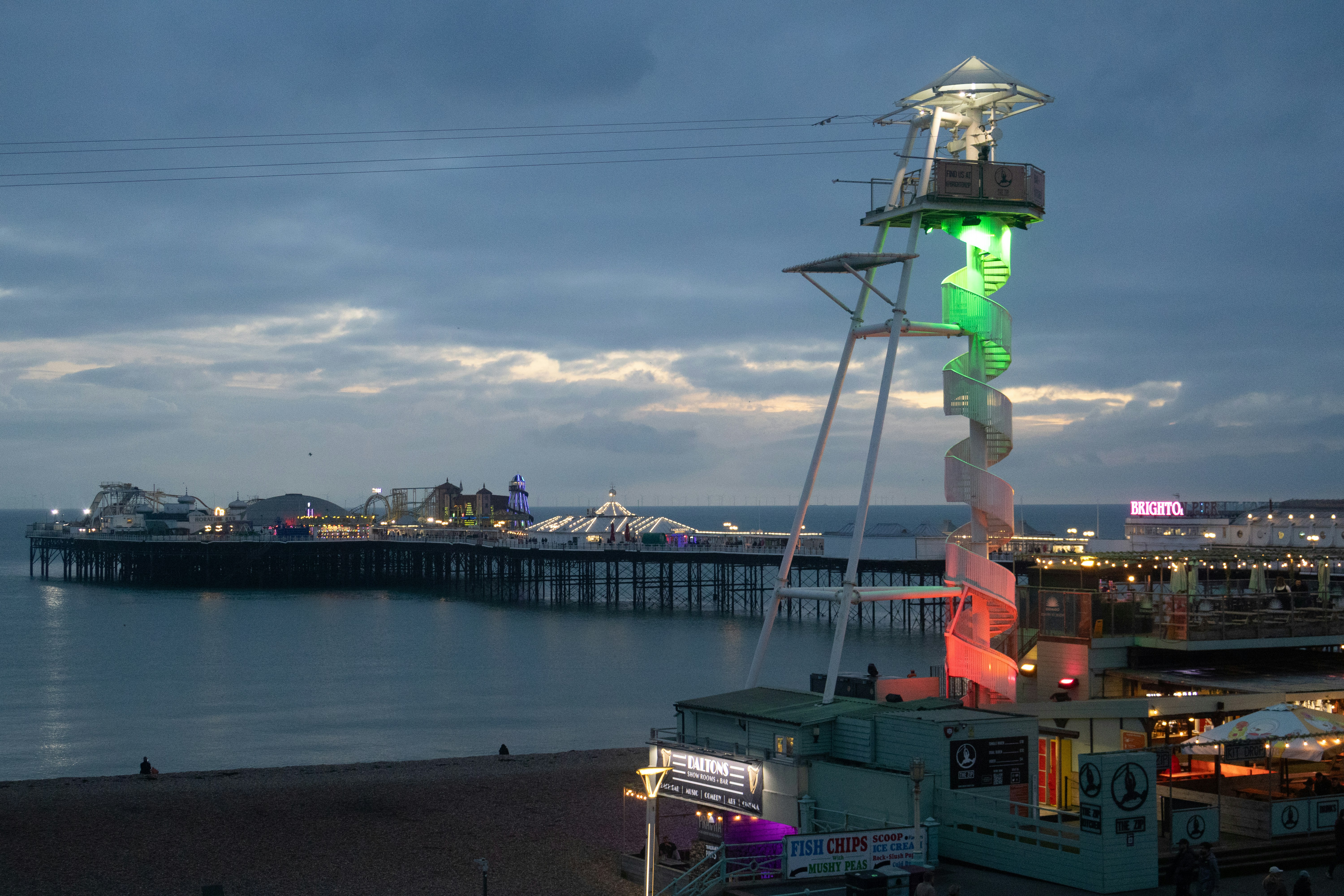 Spiral Neon Tower Lights Up a Twilight Seaside Pier