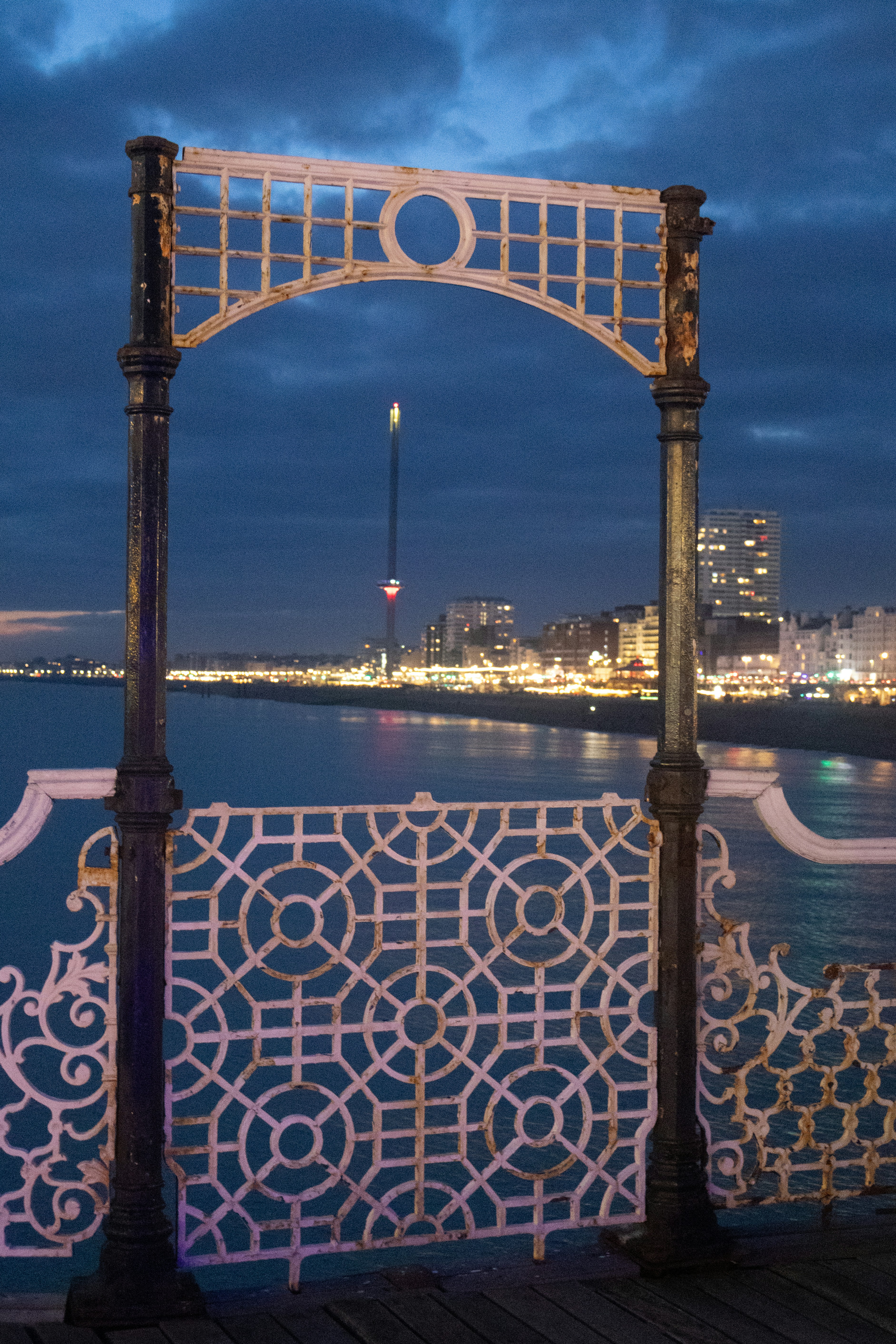 Iron Arch Framing the Waterfront: City Lights Through a Blue Hour Gate