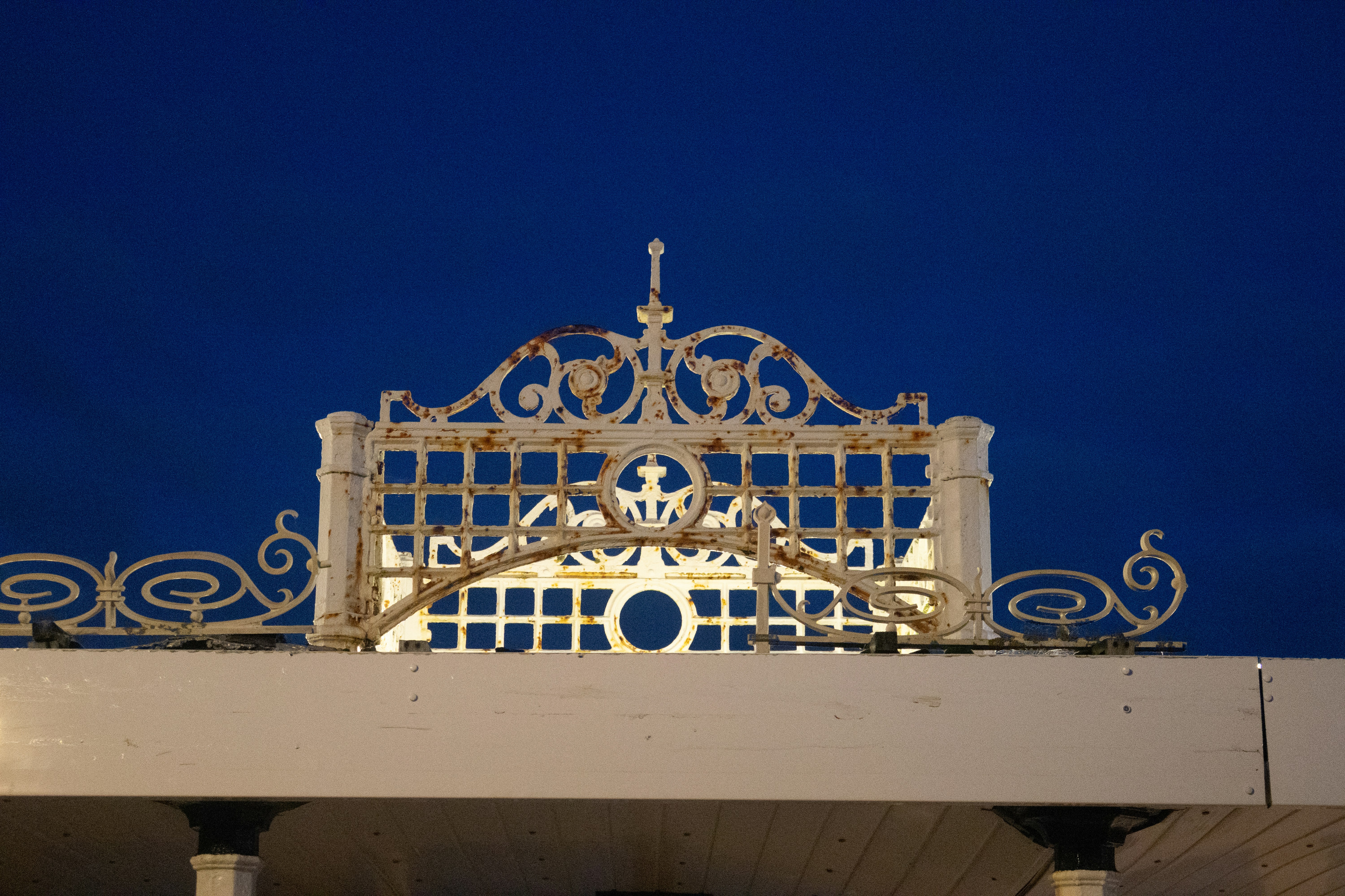 Iron Crest at Dusk: Ornate Gate Against a Velvet Sky