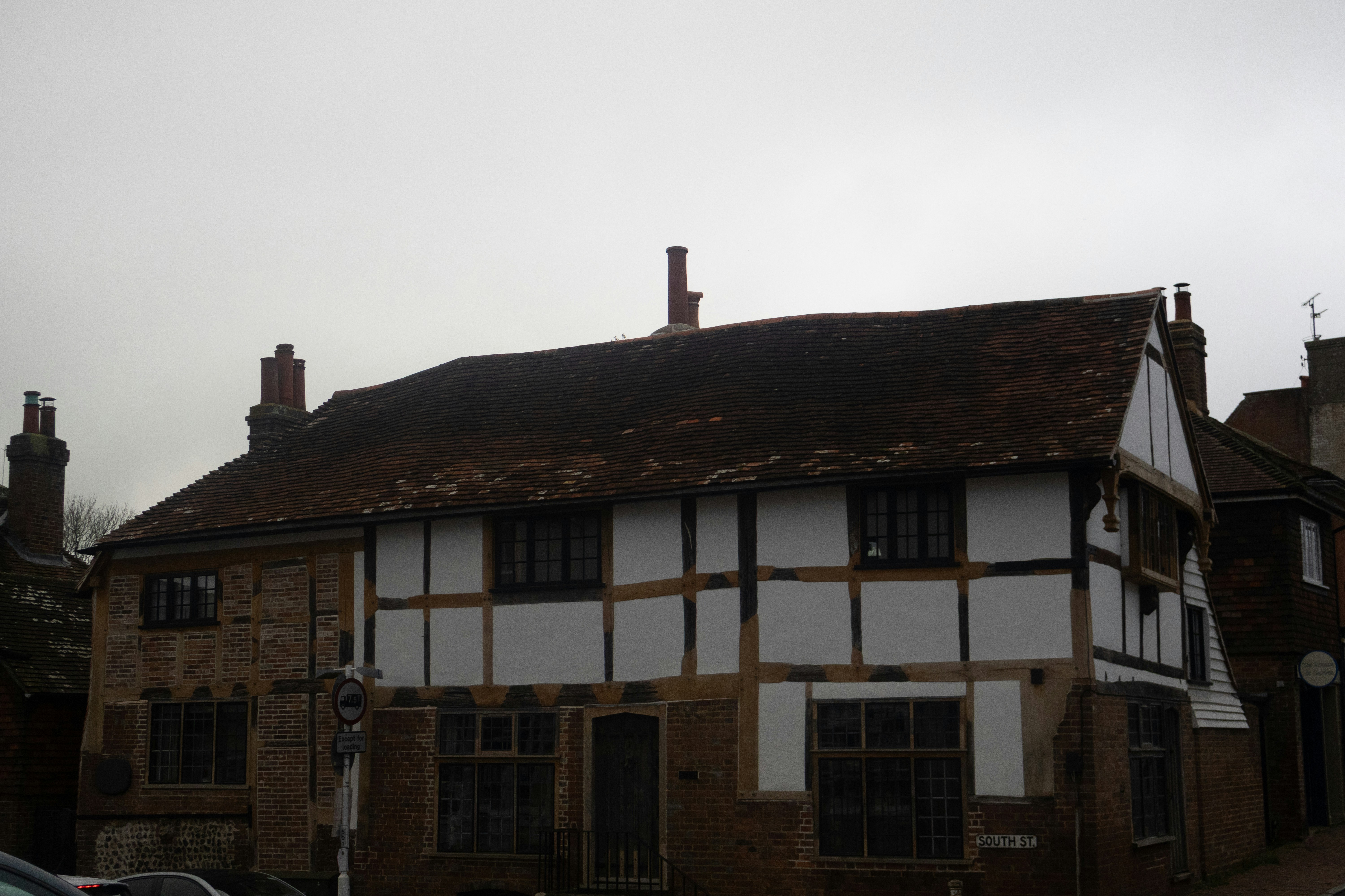 Weathered Timber and Brick: Tudor-Style Facade Under Gray Skies