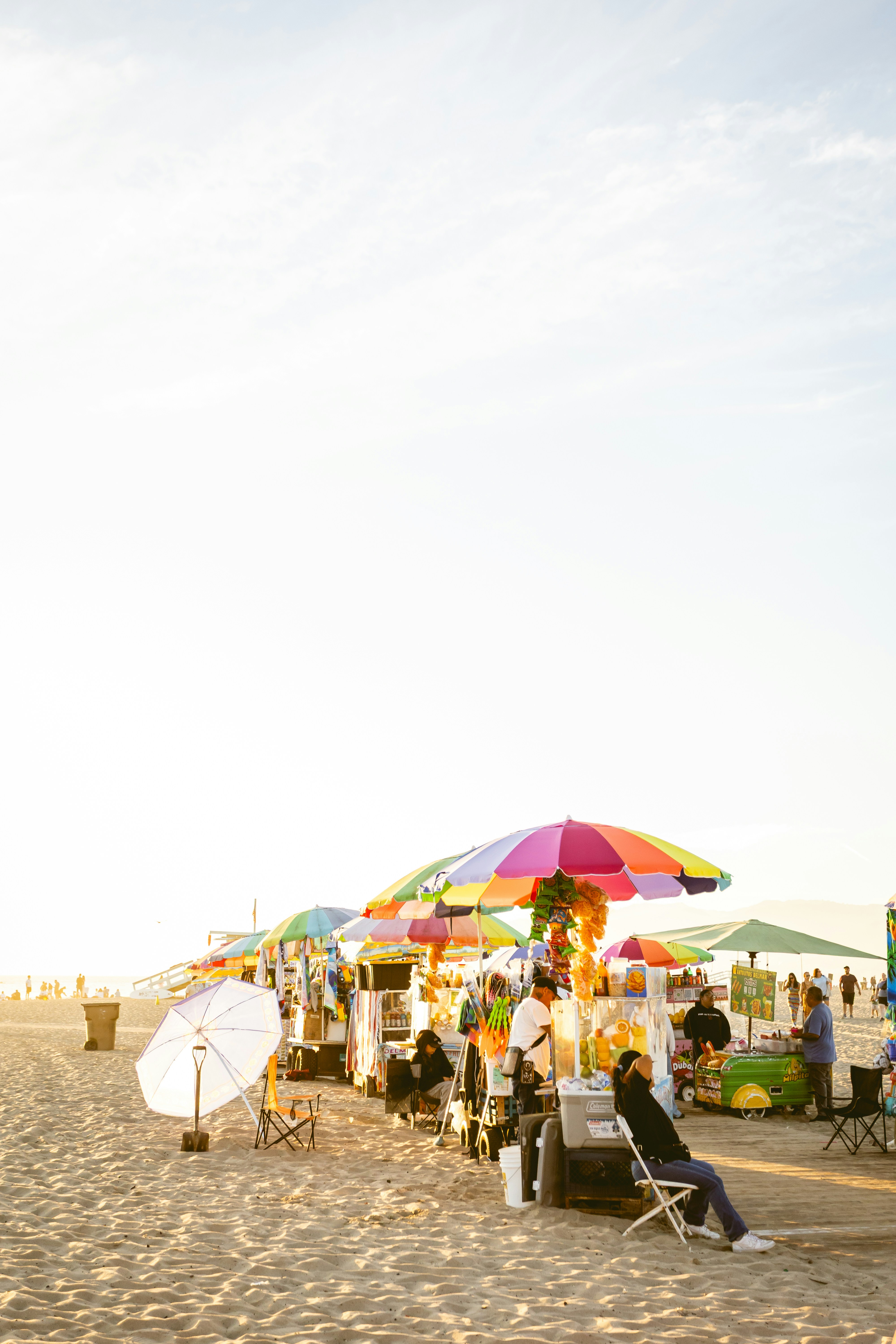 Colorful Beachfront Market Under Rainbow Umbrellas