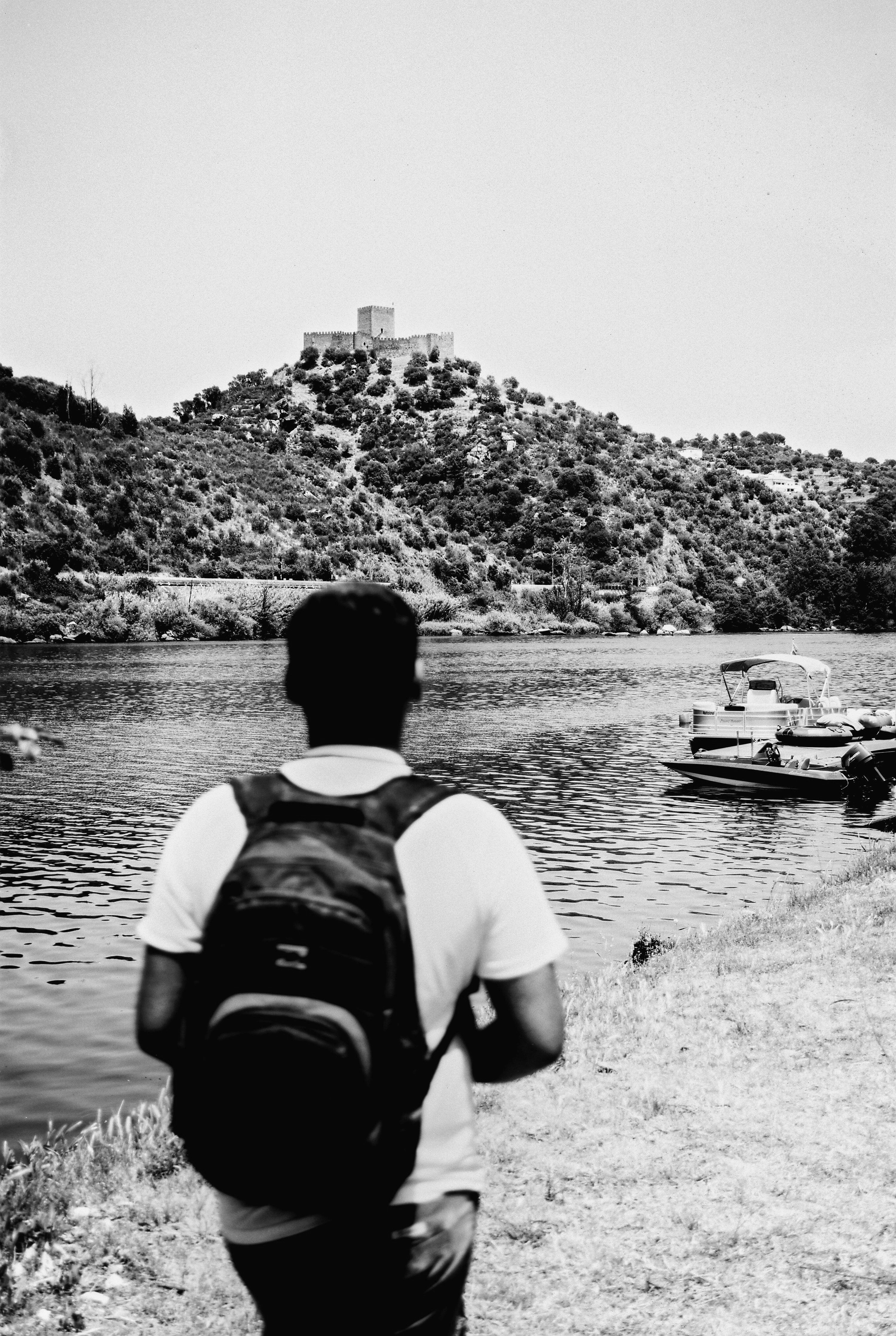 Across the Lake: A Backpacker Gazes Toward the Hilltop Fortress