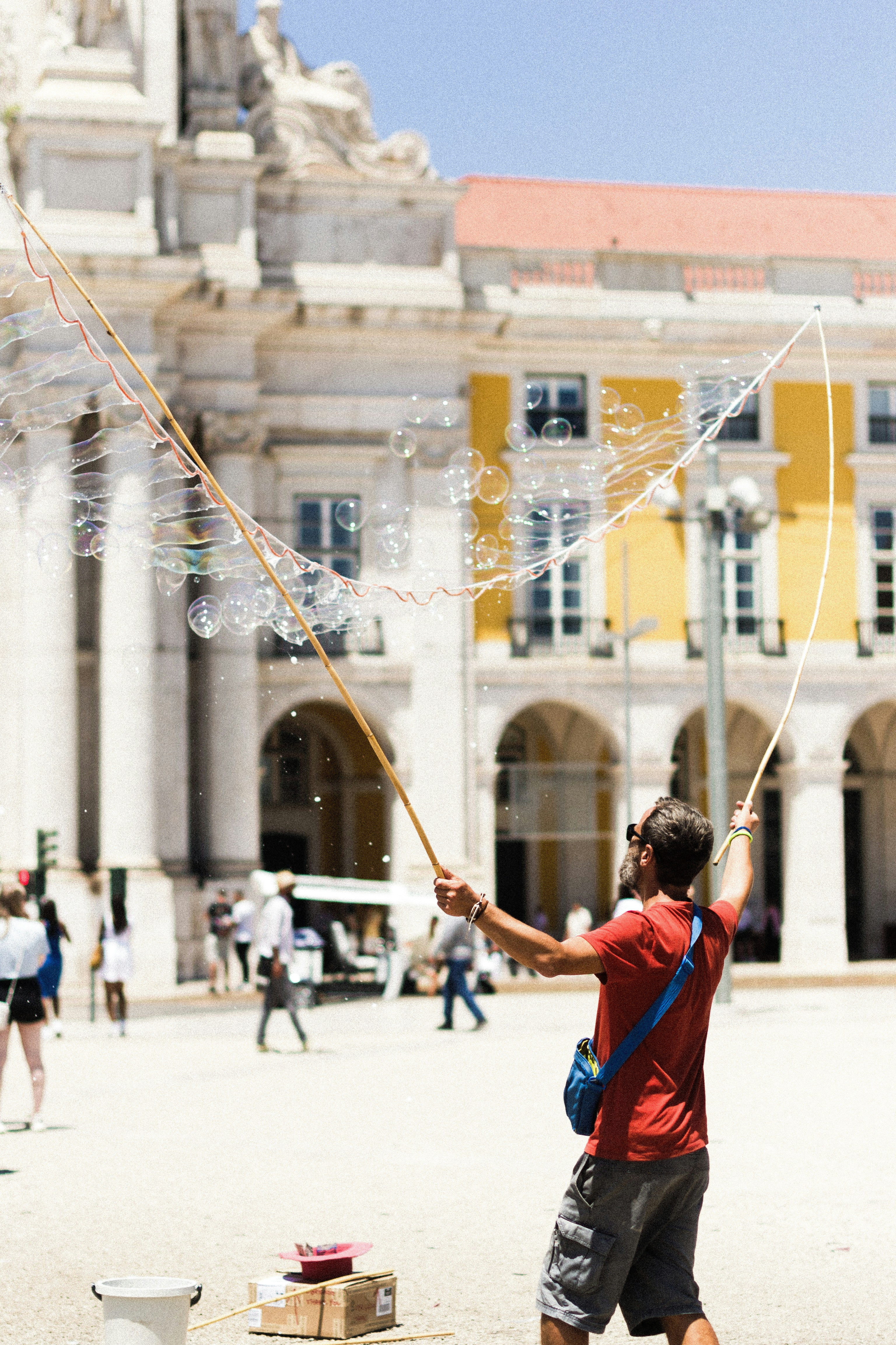 Bubble Threads Under Sunlit Arches: A Plaza Moment