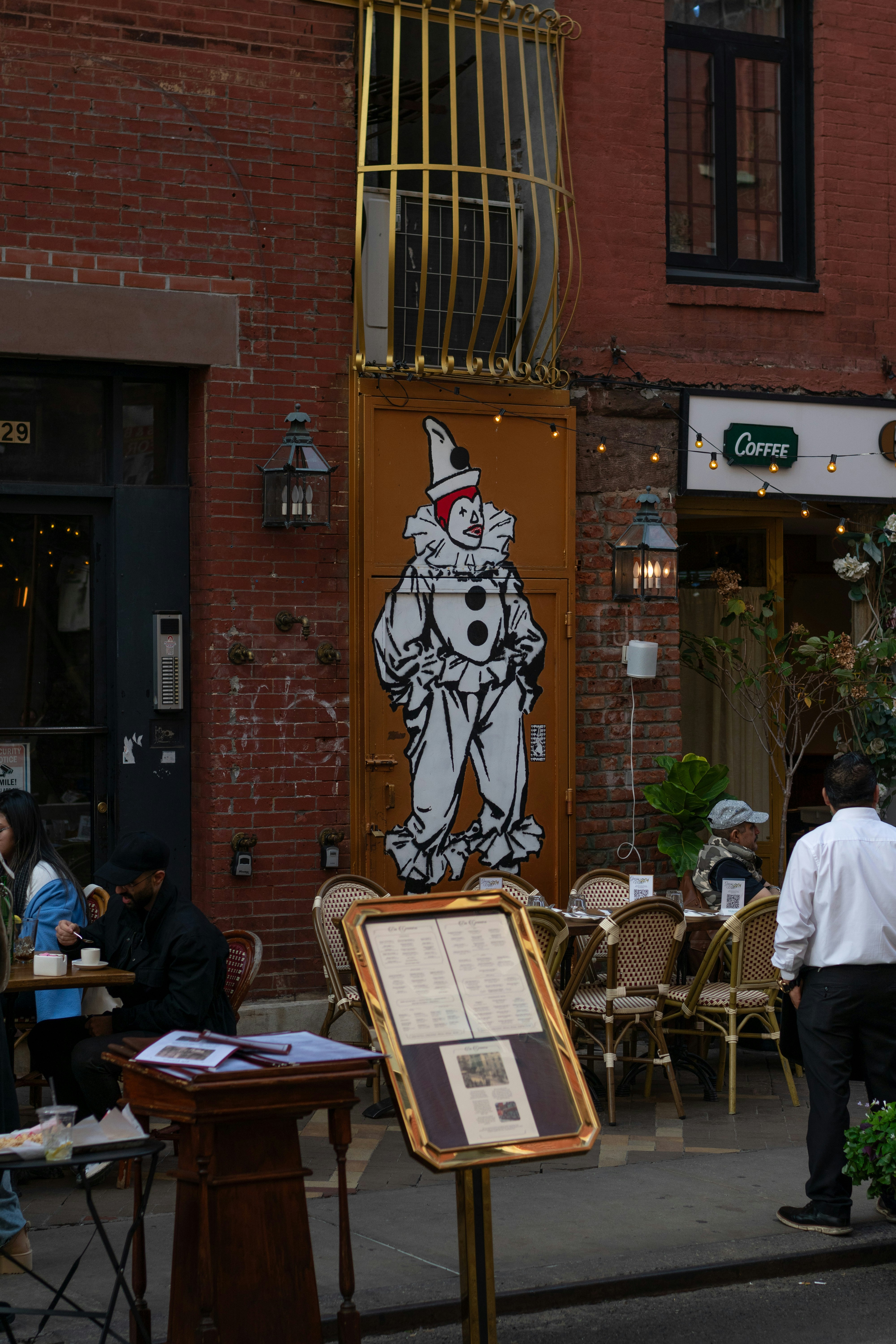 Mustard Door Clown: A mural that anchors a lively brick-cafe street