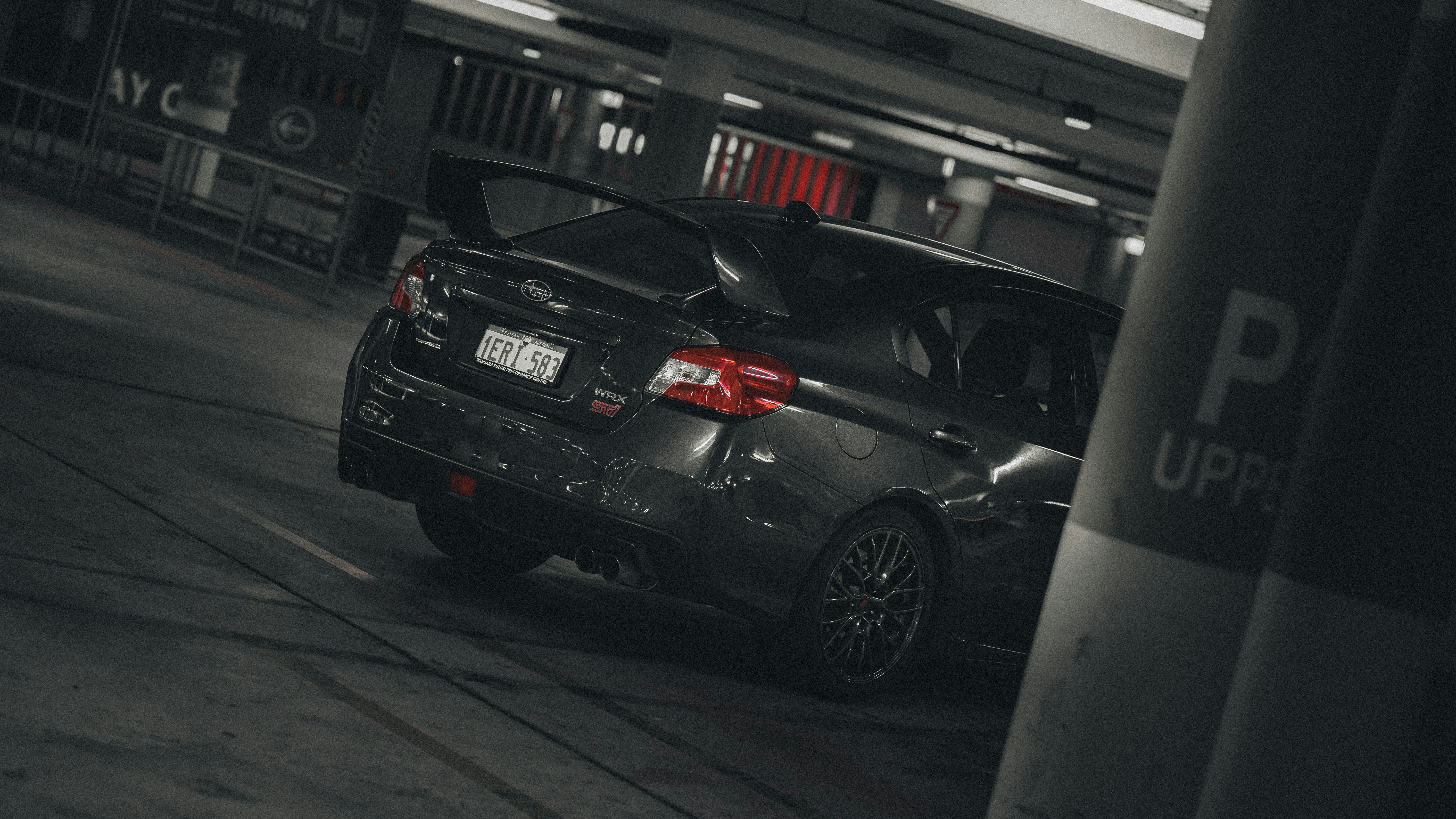 Noir Sedan Under Fluorescent Grids