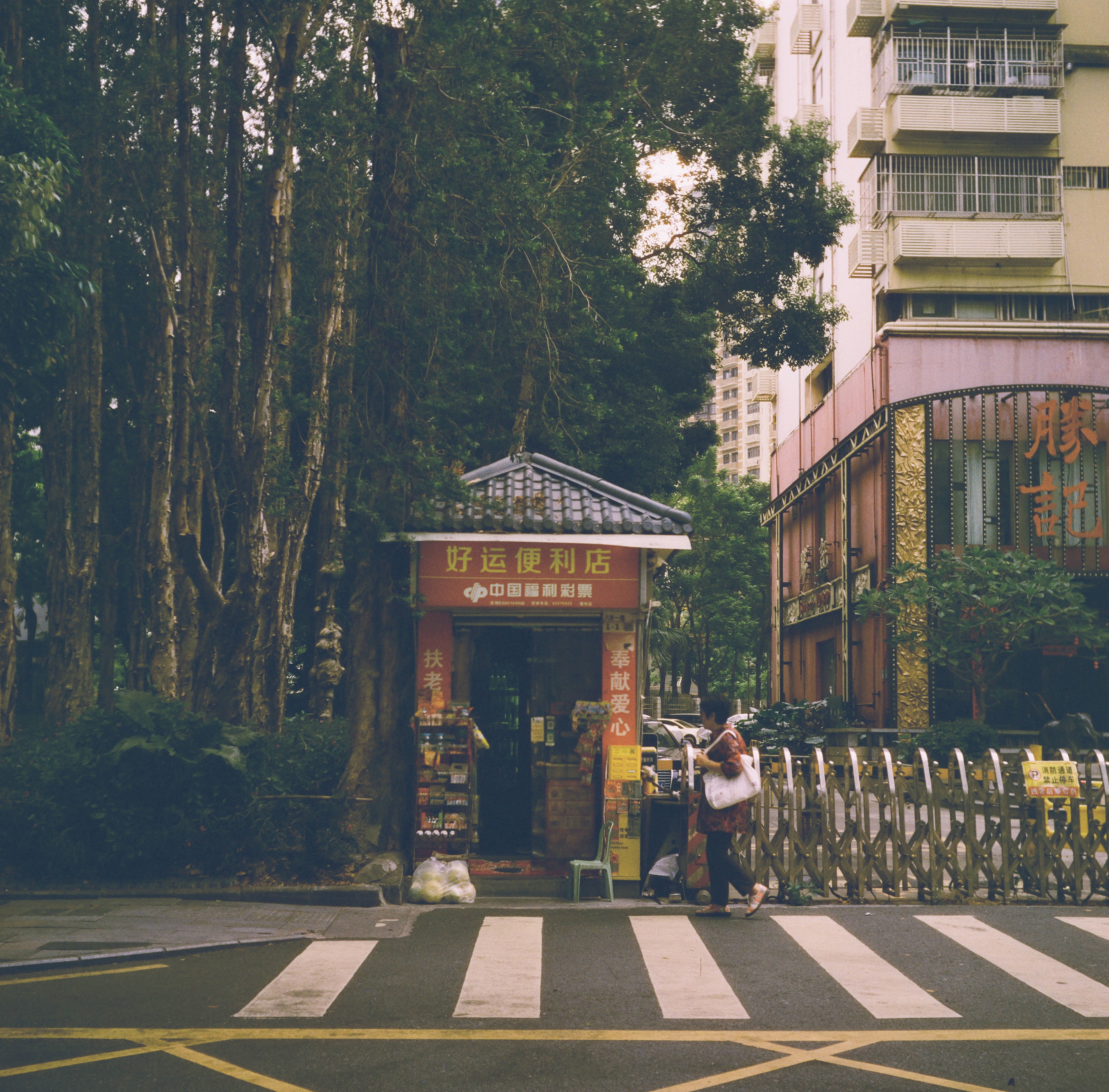 Small storefront with people crossing street