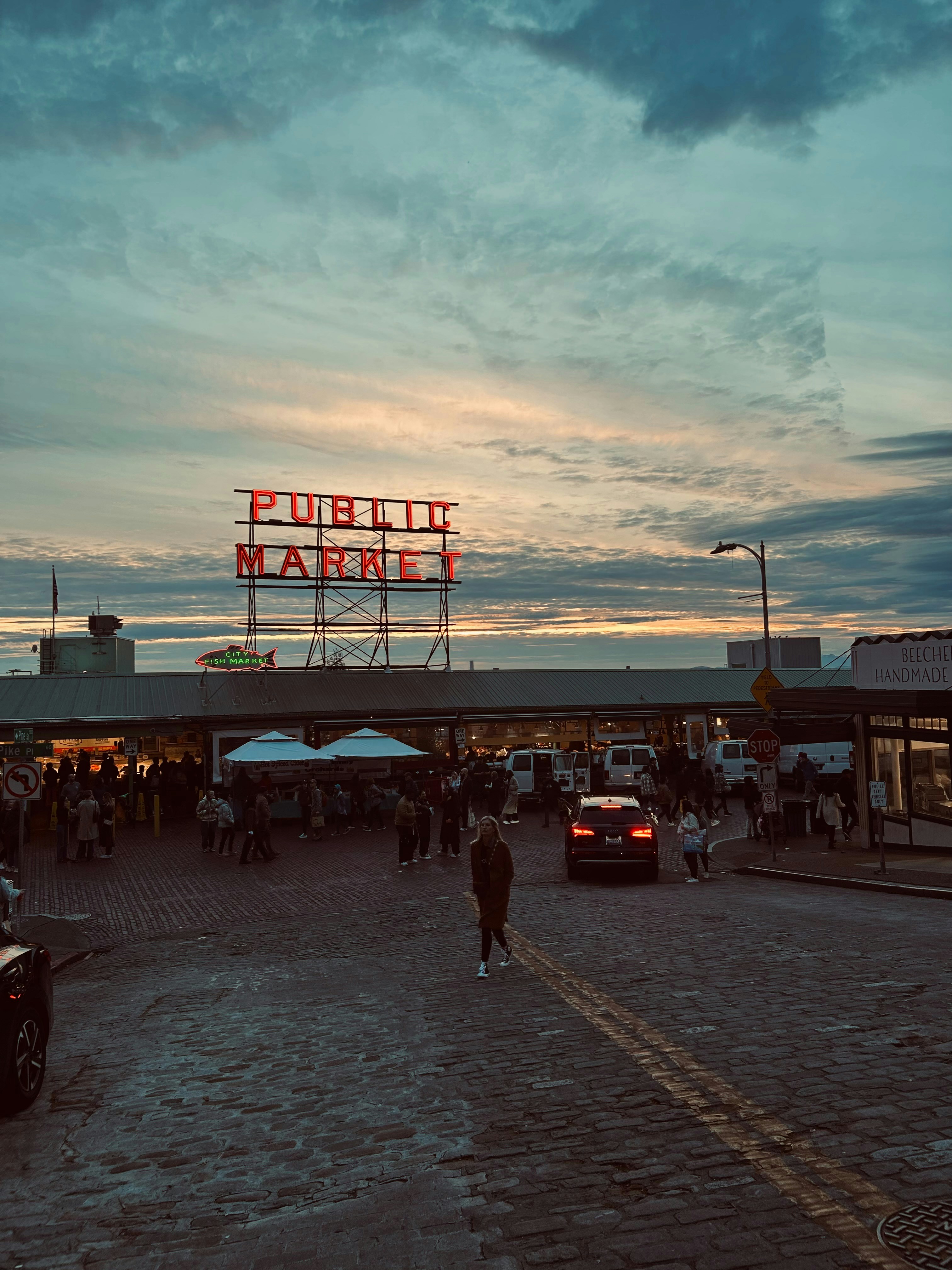Neon Sign Over a Bustling Public Market at Dusk