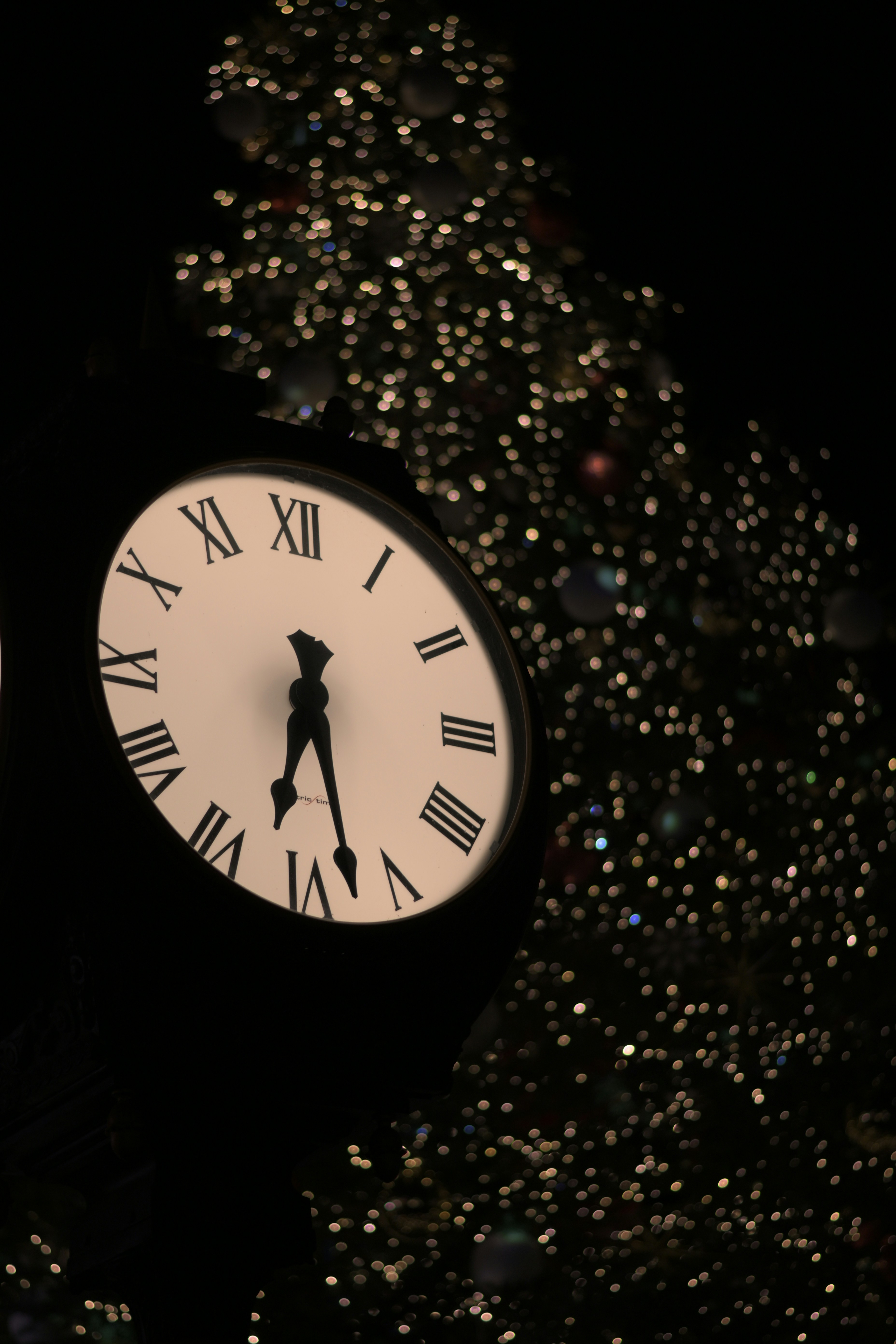 A clock face with roman numerals at night.