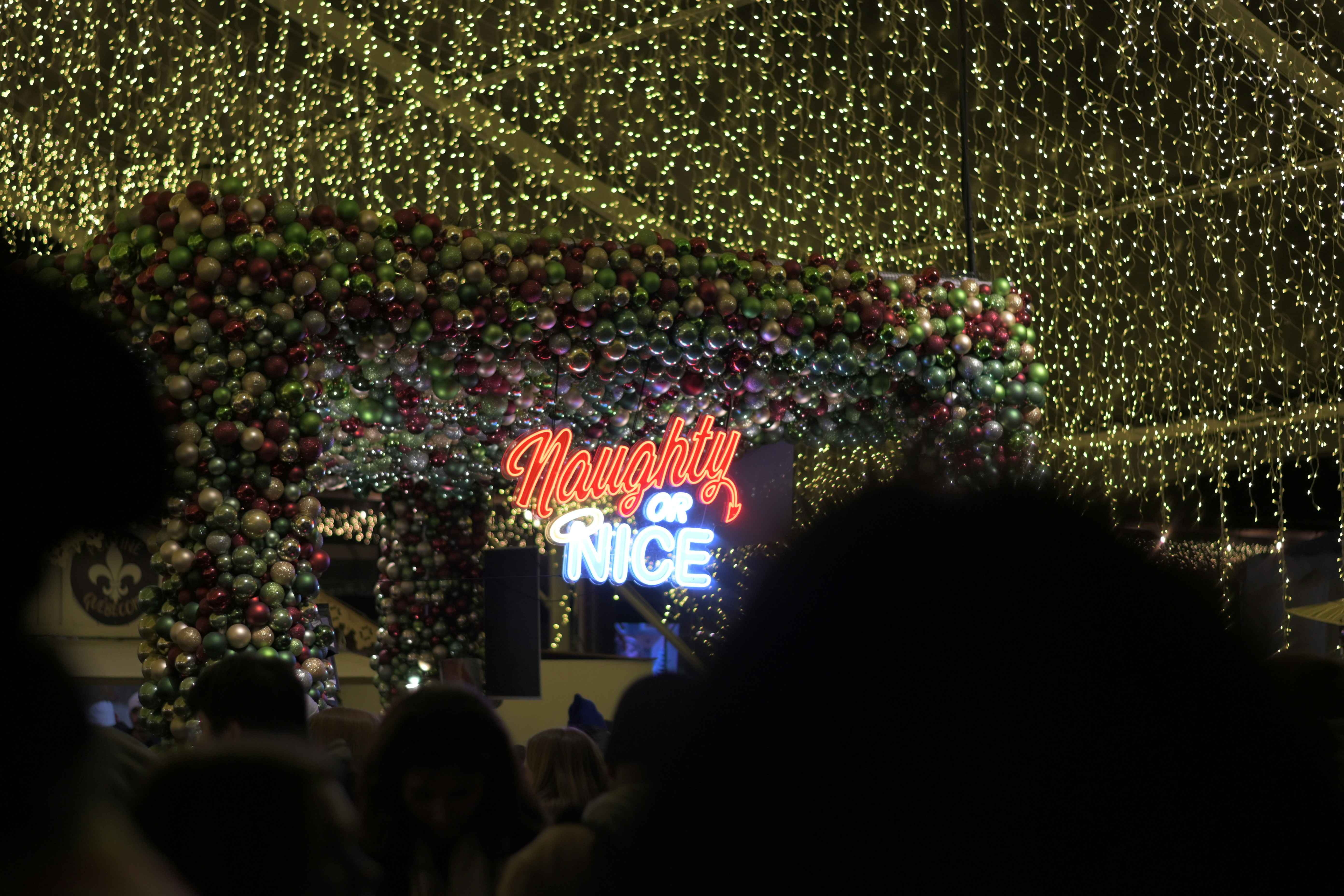 Naughty or Nice Neon Sign Surrounded by a Sparkling Balloon Arch