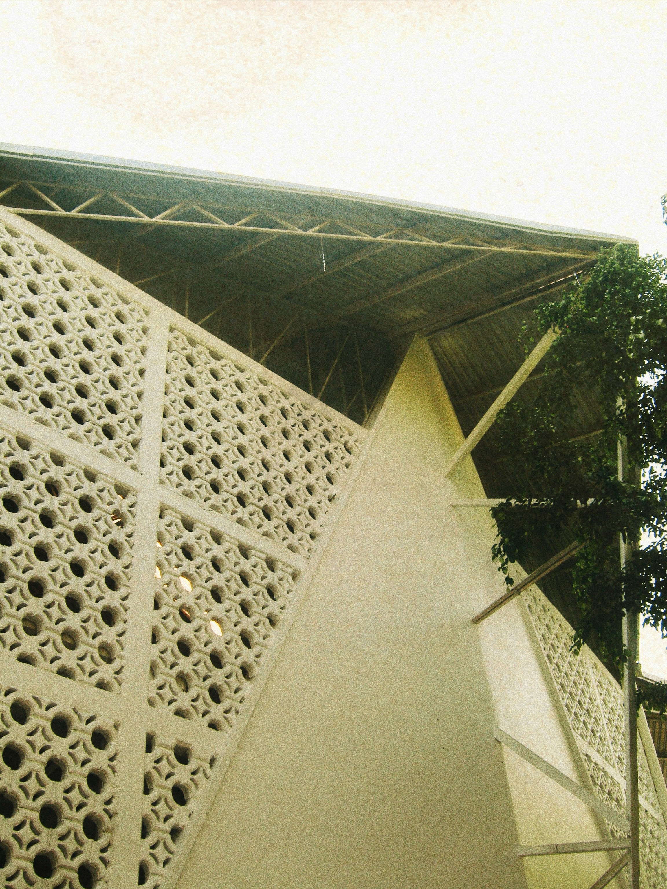 Modern building with patterned concrete walls and metal roof.