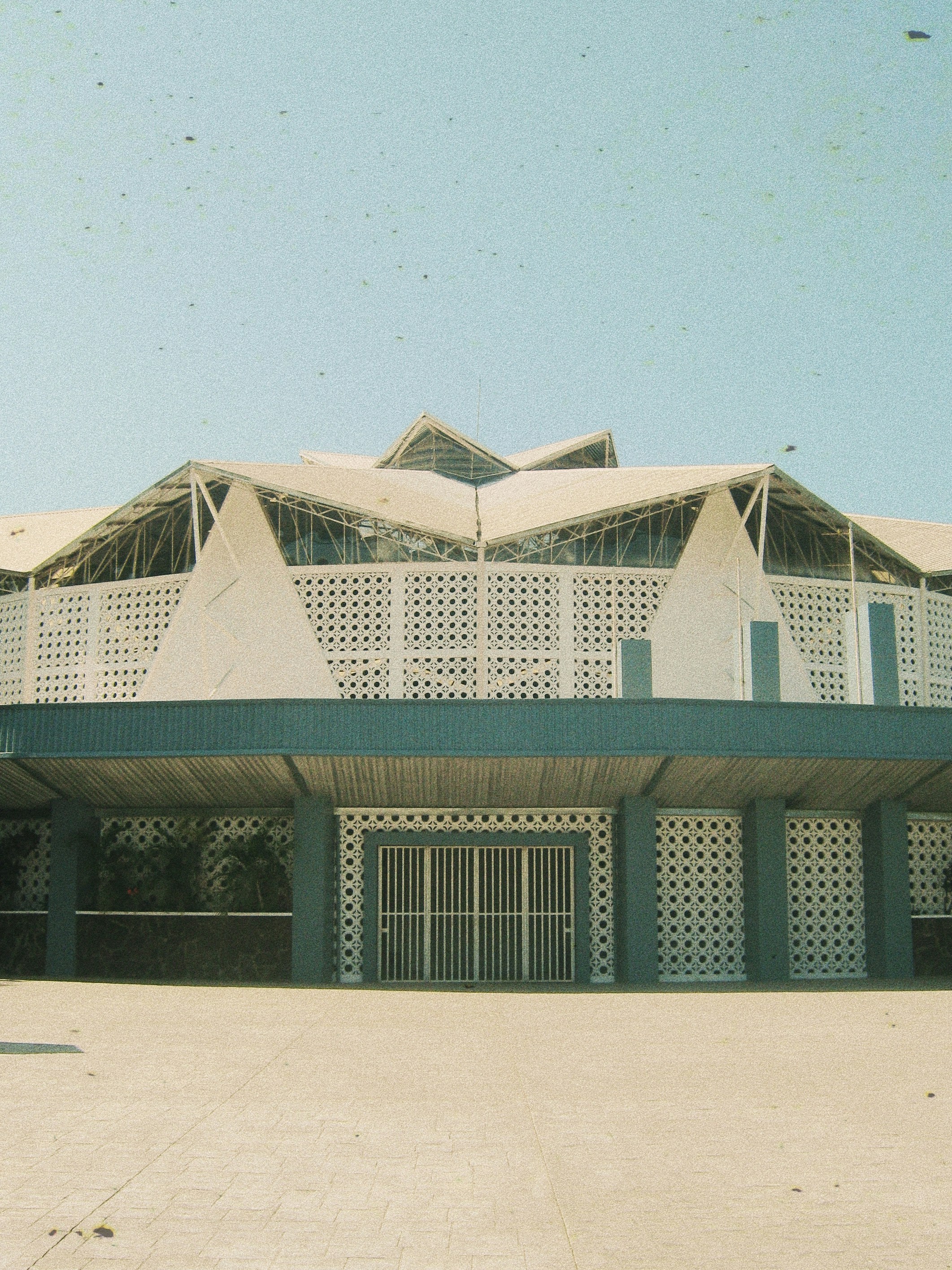 Modern building with geometric facade and large entrance.