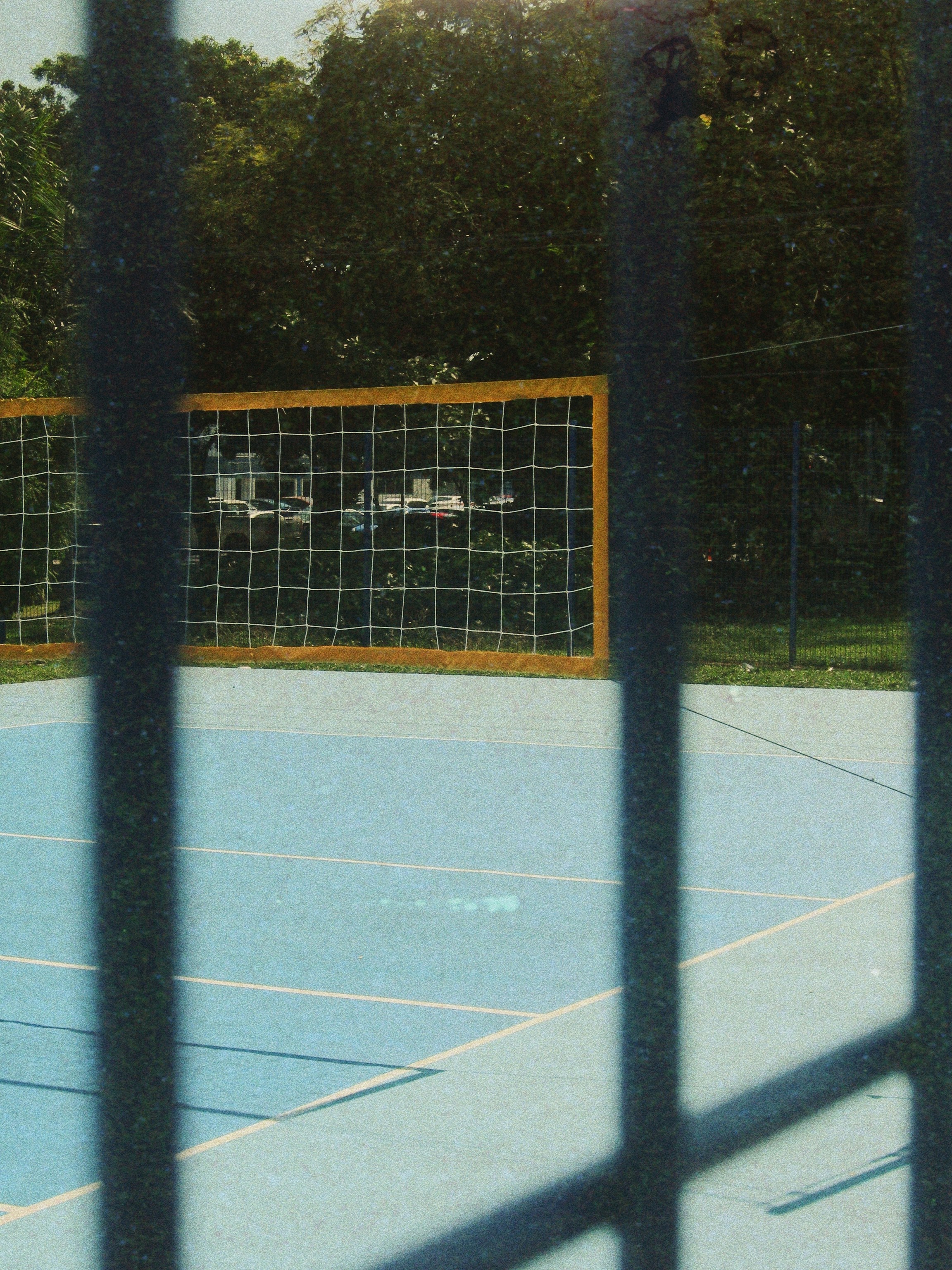A blue court with a yellow-framed net.