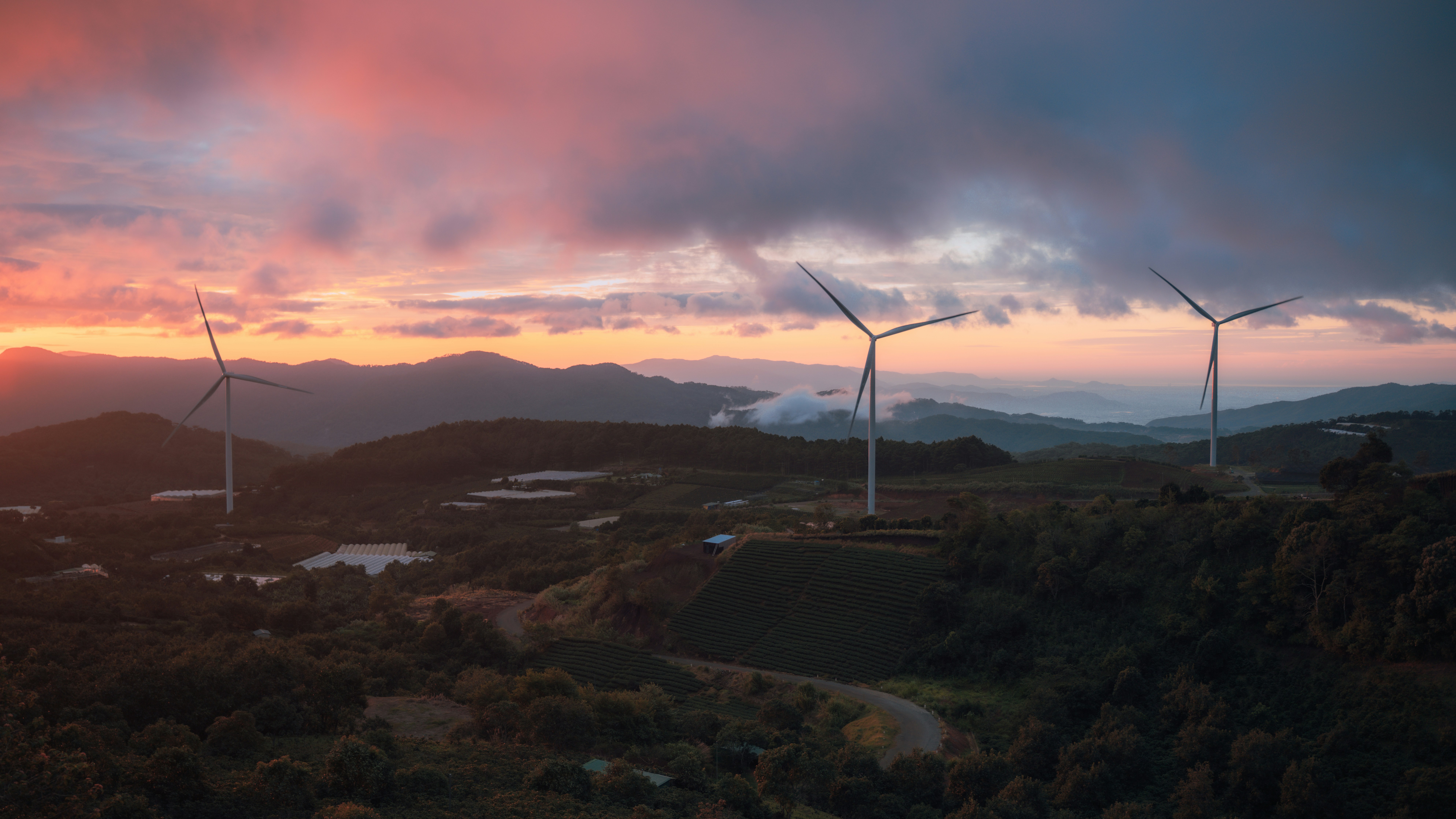 Sunset Silhouettes: Trio of Wind Turbines on Rolling Hills
