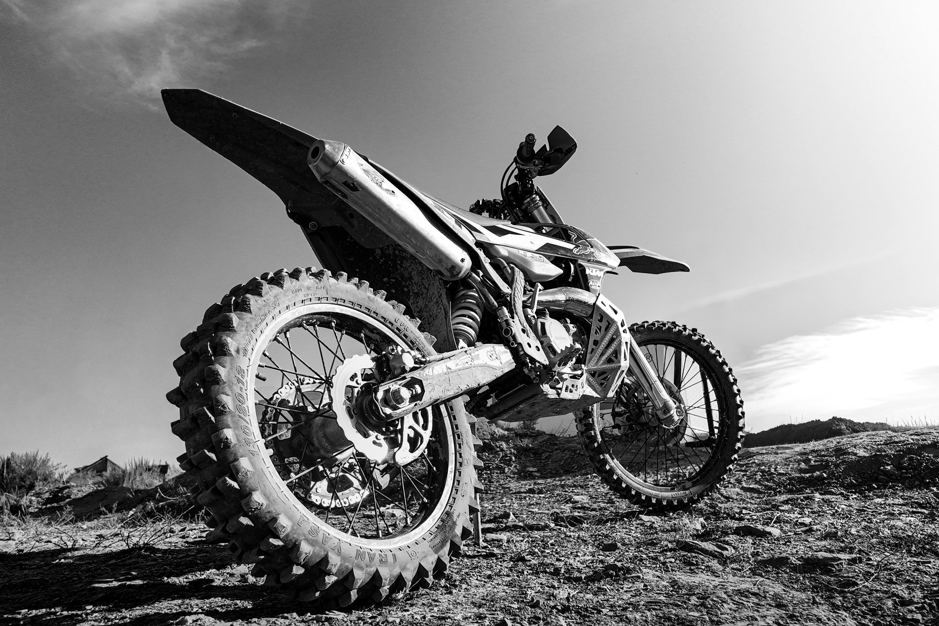 Dirt bike parked on a dusty hill under sky