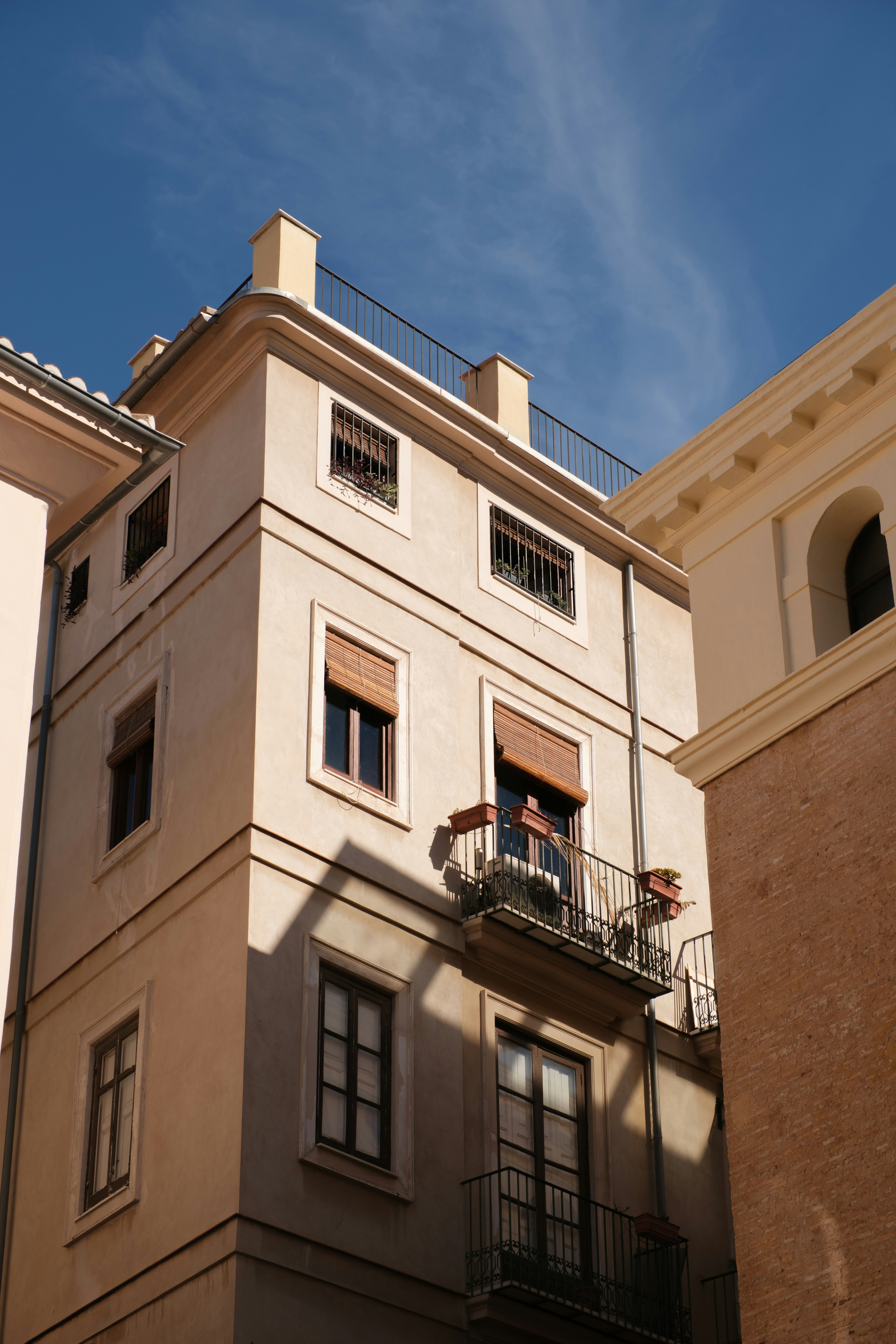 Sunlit Balcony Portrait on a Mediterranean-Style Urban Façade