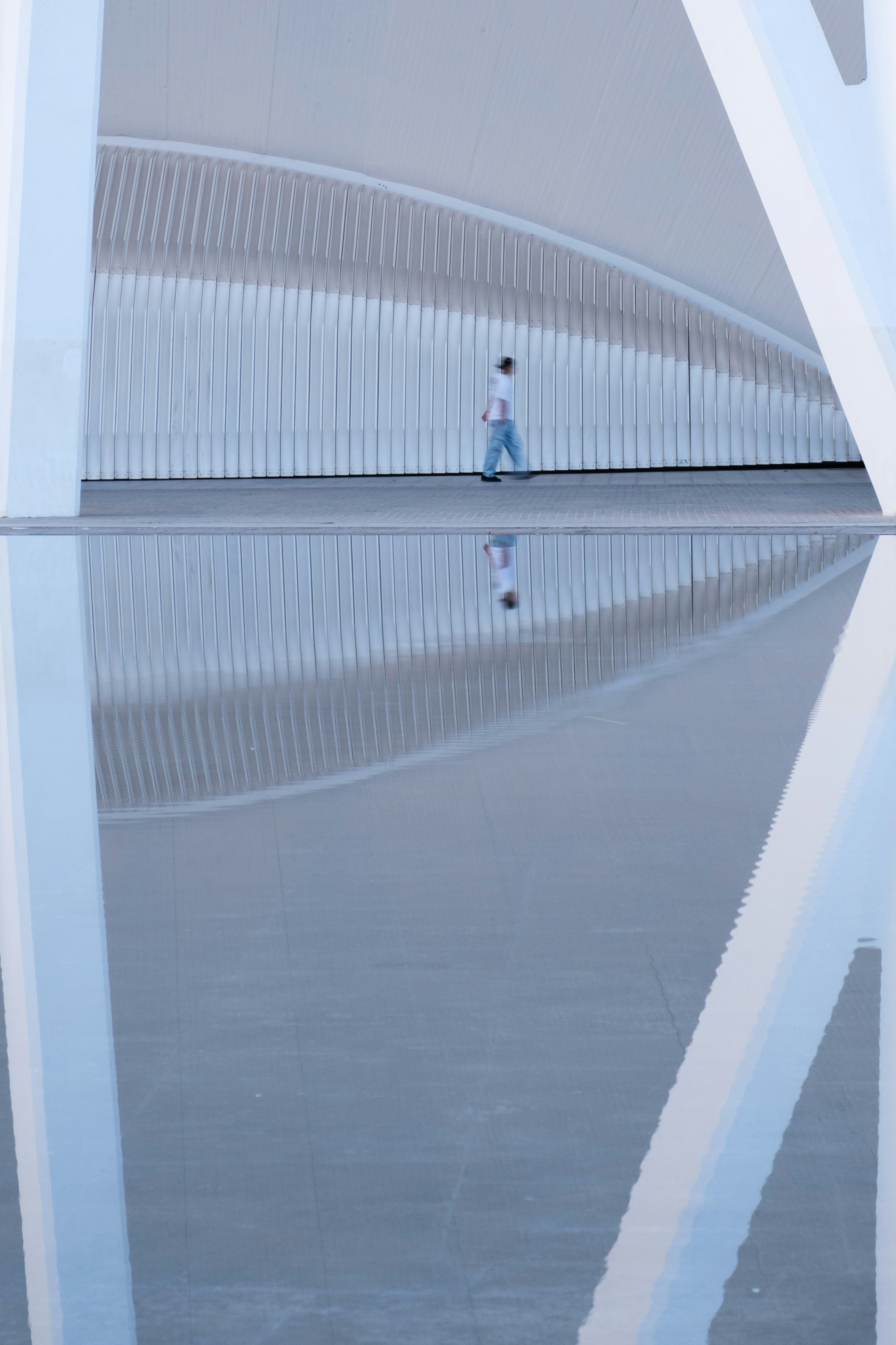 Lone Walker in a Mirror-Arch Corridor