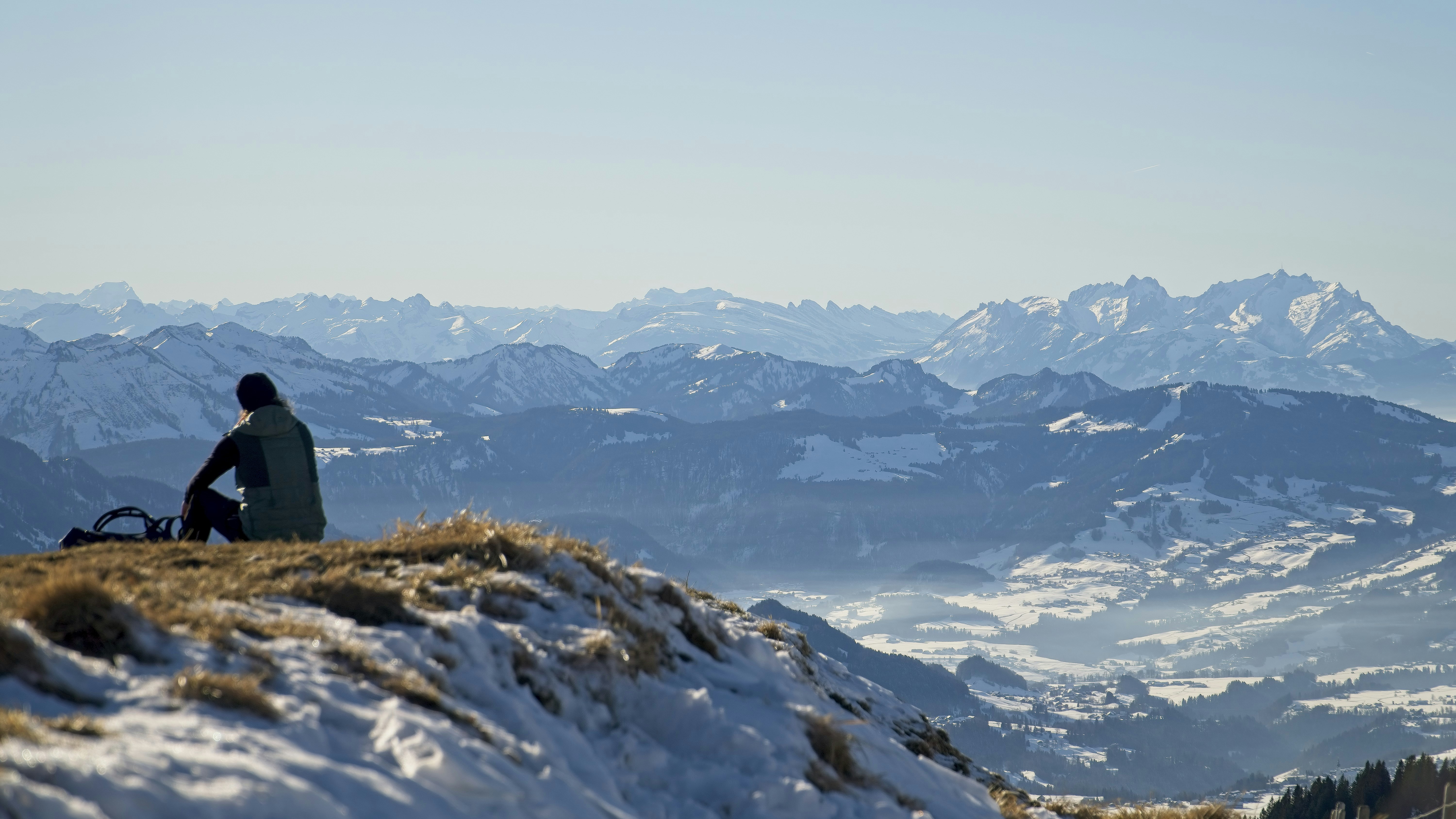 Ridgewalker at Dawn: A Lone Hiker Gazes Across a Snow-Blue Alpine Panorama