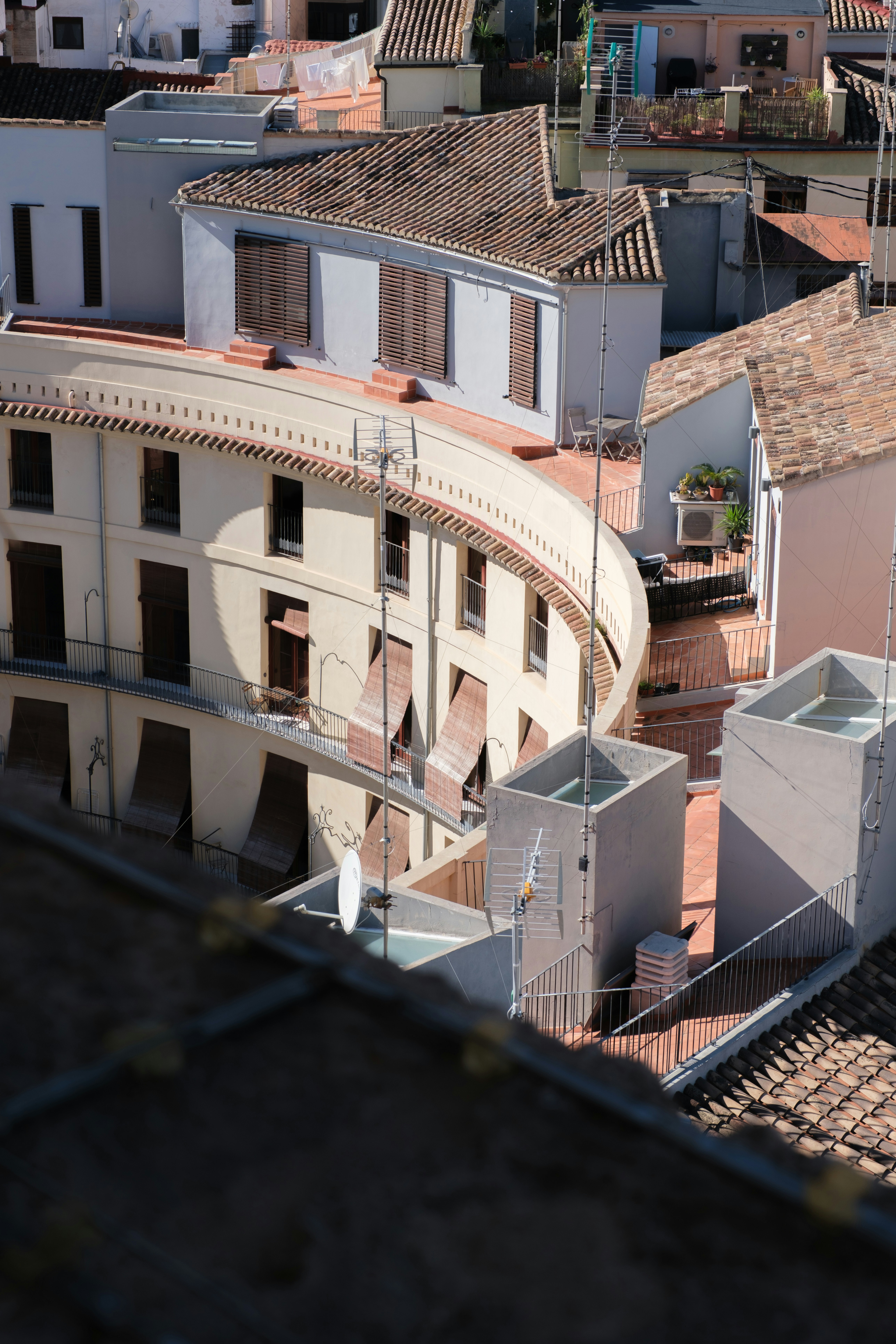 Crescent Courtyard: Sunlit Arches Among Rooftop Terraces