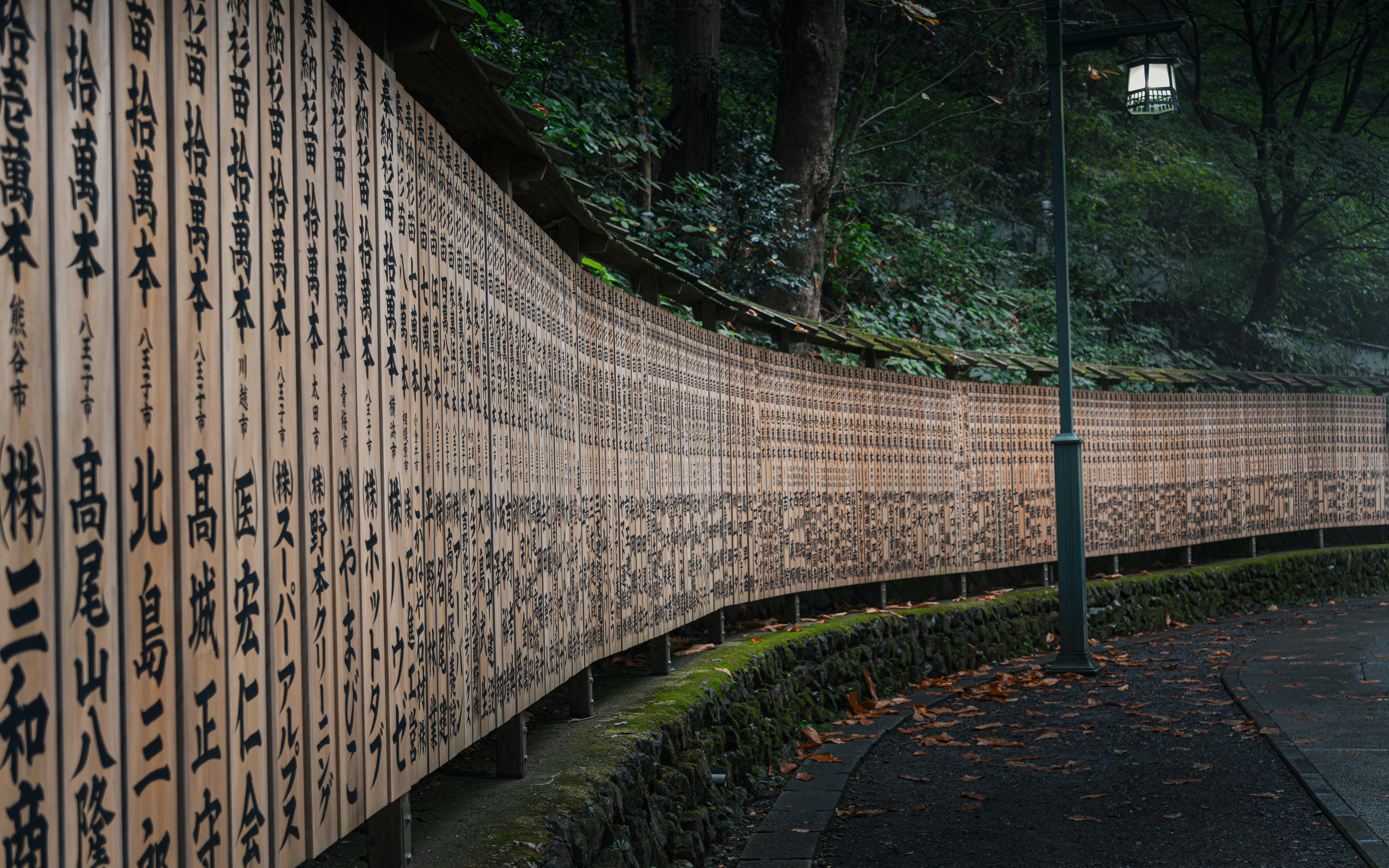 Kanji Corridor at Dusk: A Curved Wall of Names Along a Lantern-lit Path