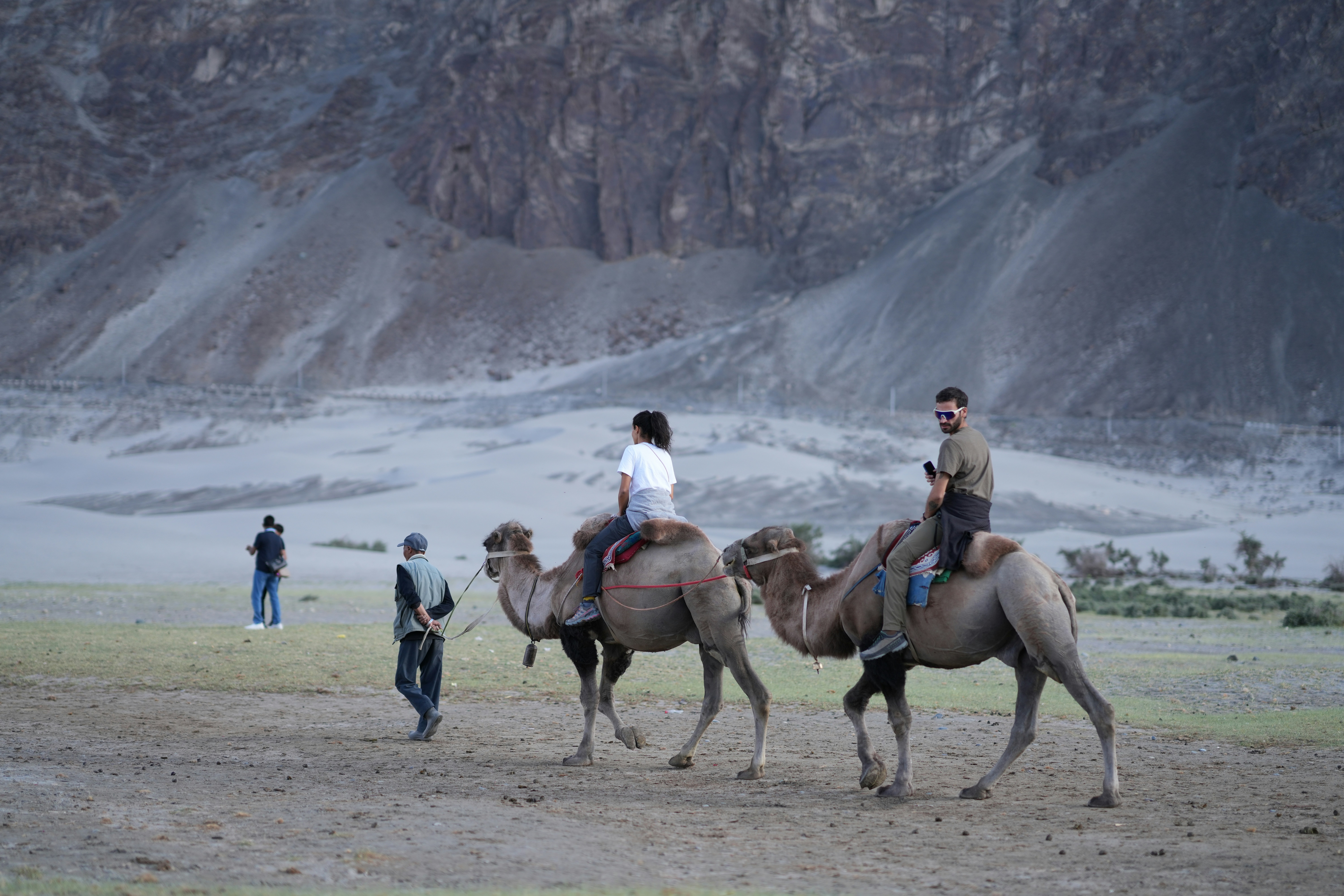 Desert Caravan Along a Lunar Valley under Craggy Cliffs