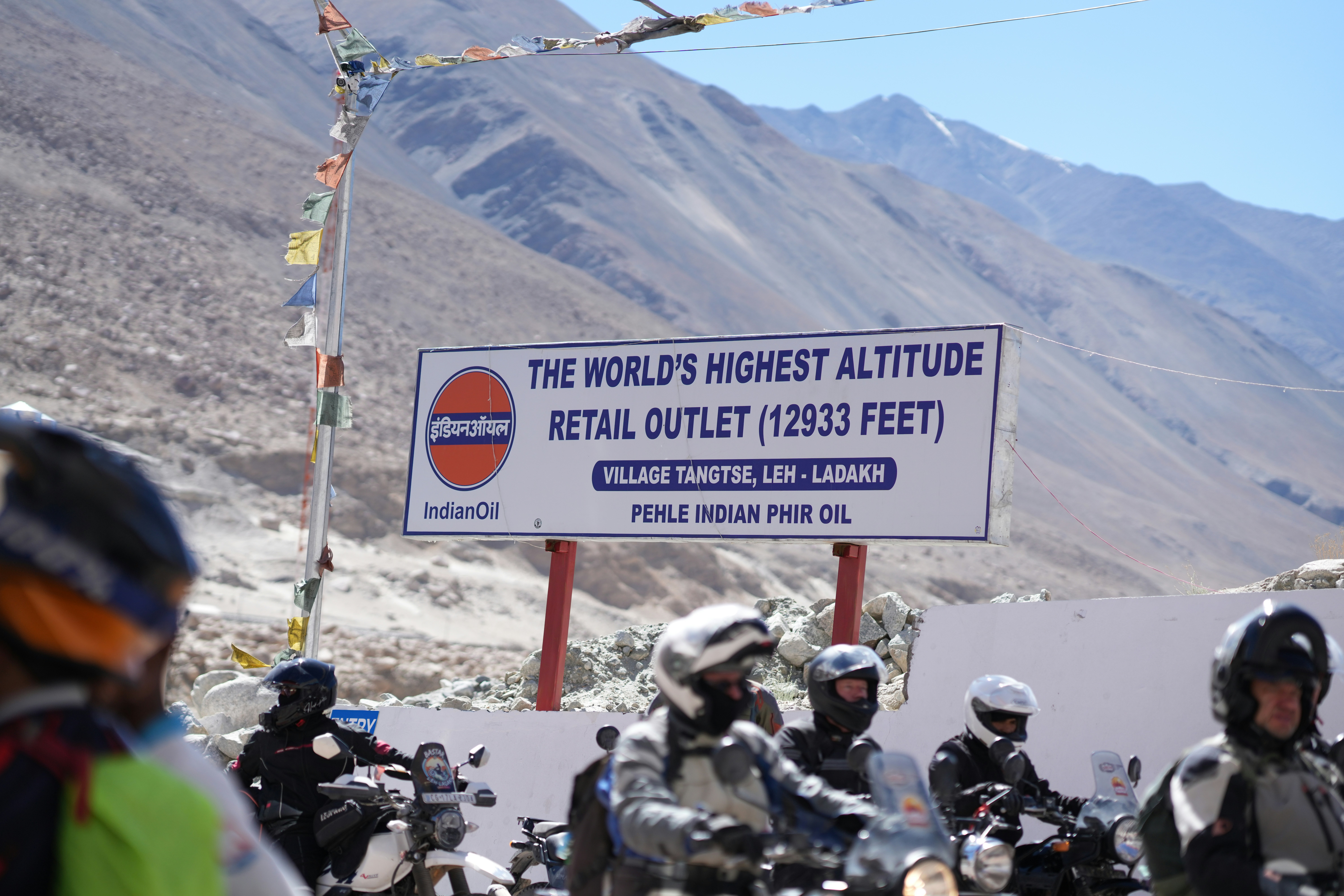 Summit Stop: Motorbikes and Prayer Flags at a High-Altitude Retail Sign