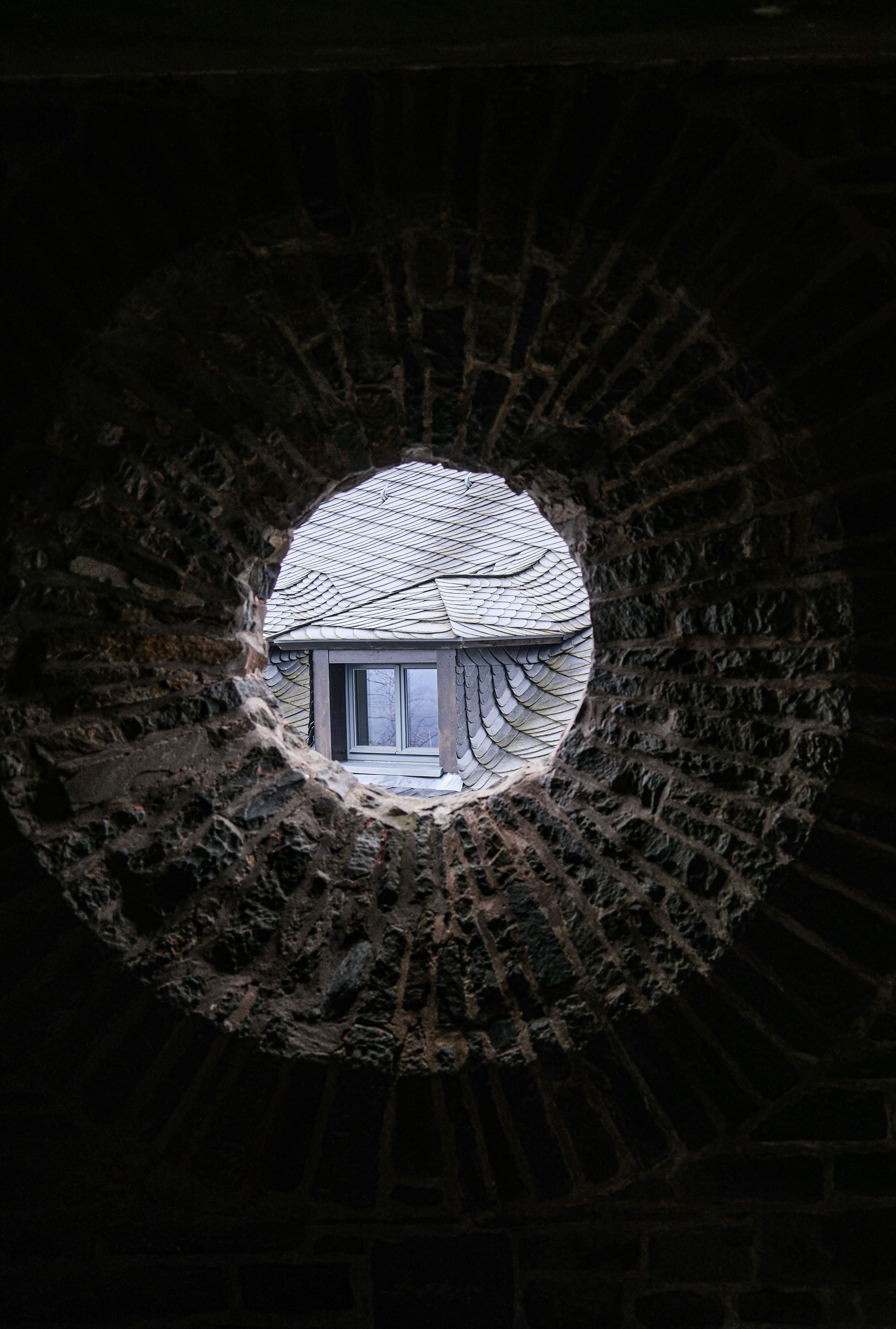 Brick Ring Aperture: A Quiet Rooftop Window Framed by Darkness