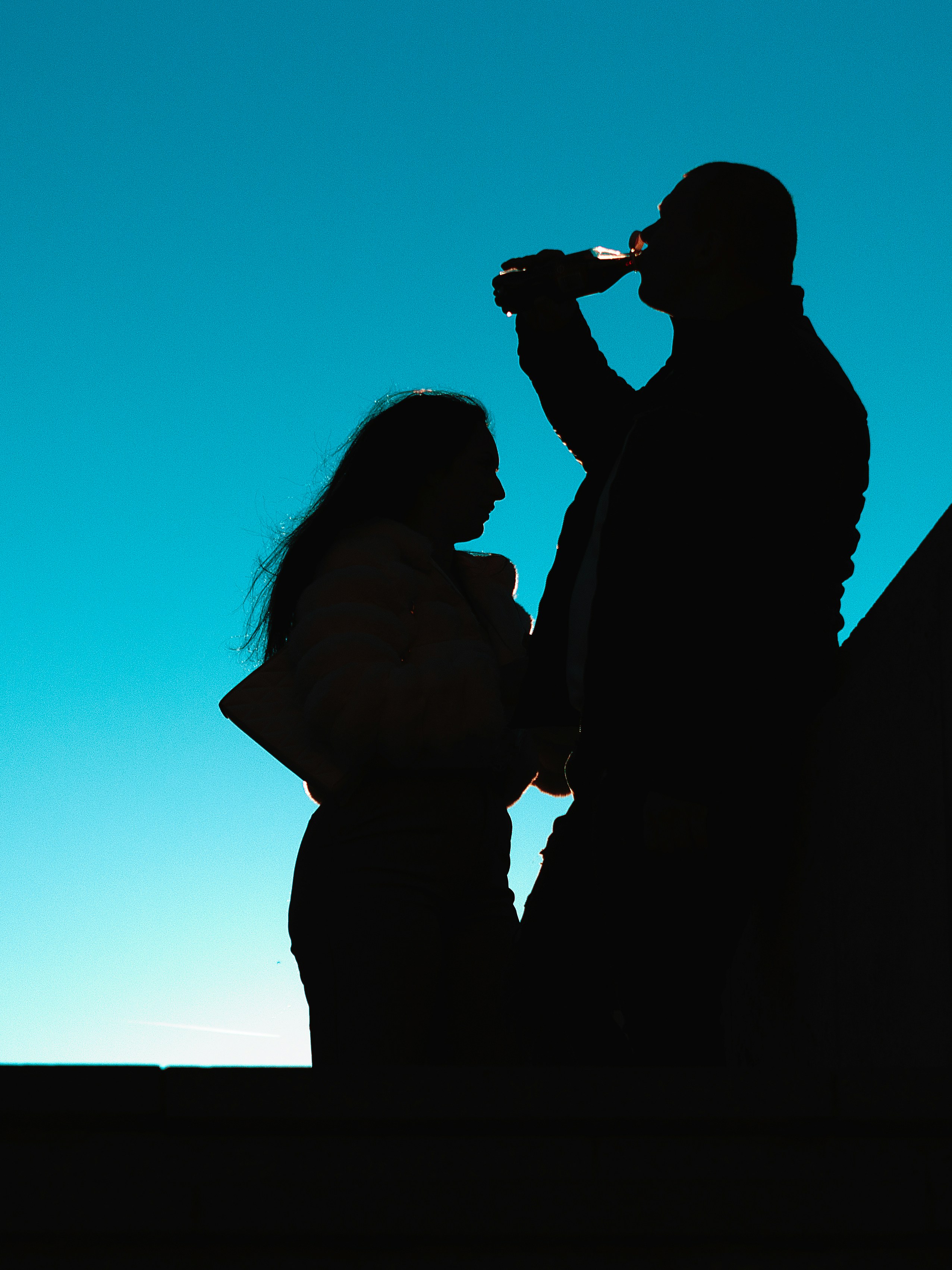 Cerulean Skyline: Silhouettes Share a Quiet Toast