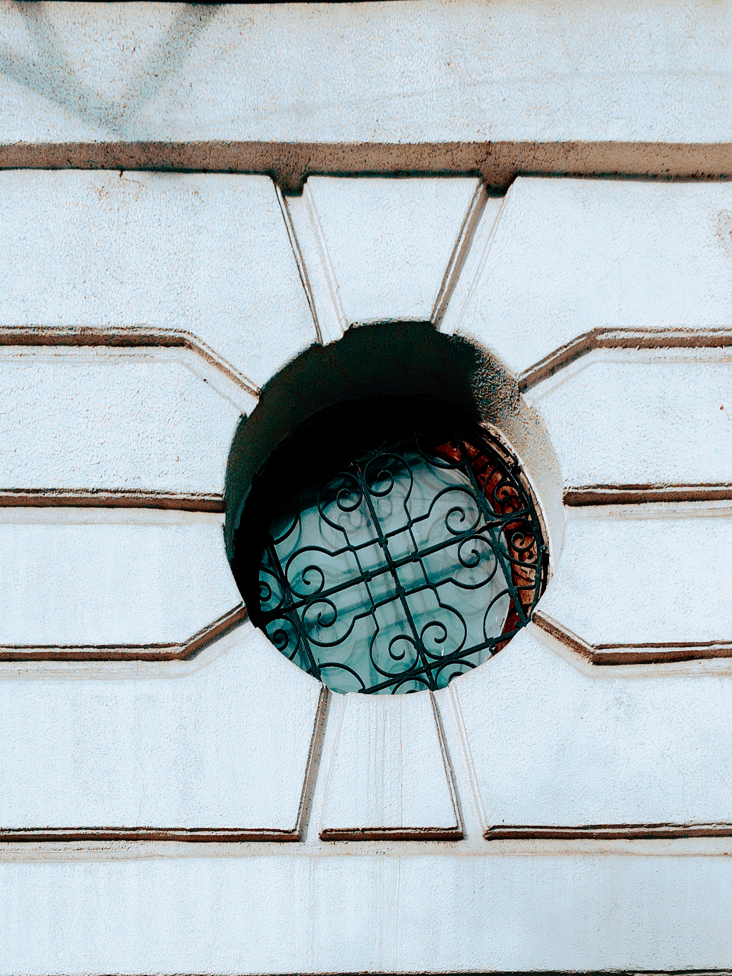 Circular window with decorative metal grate