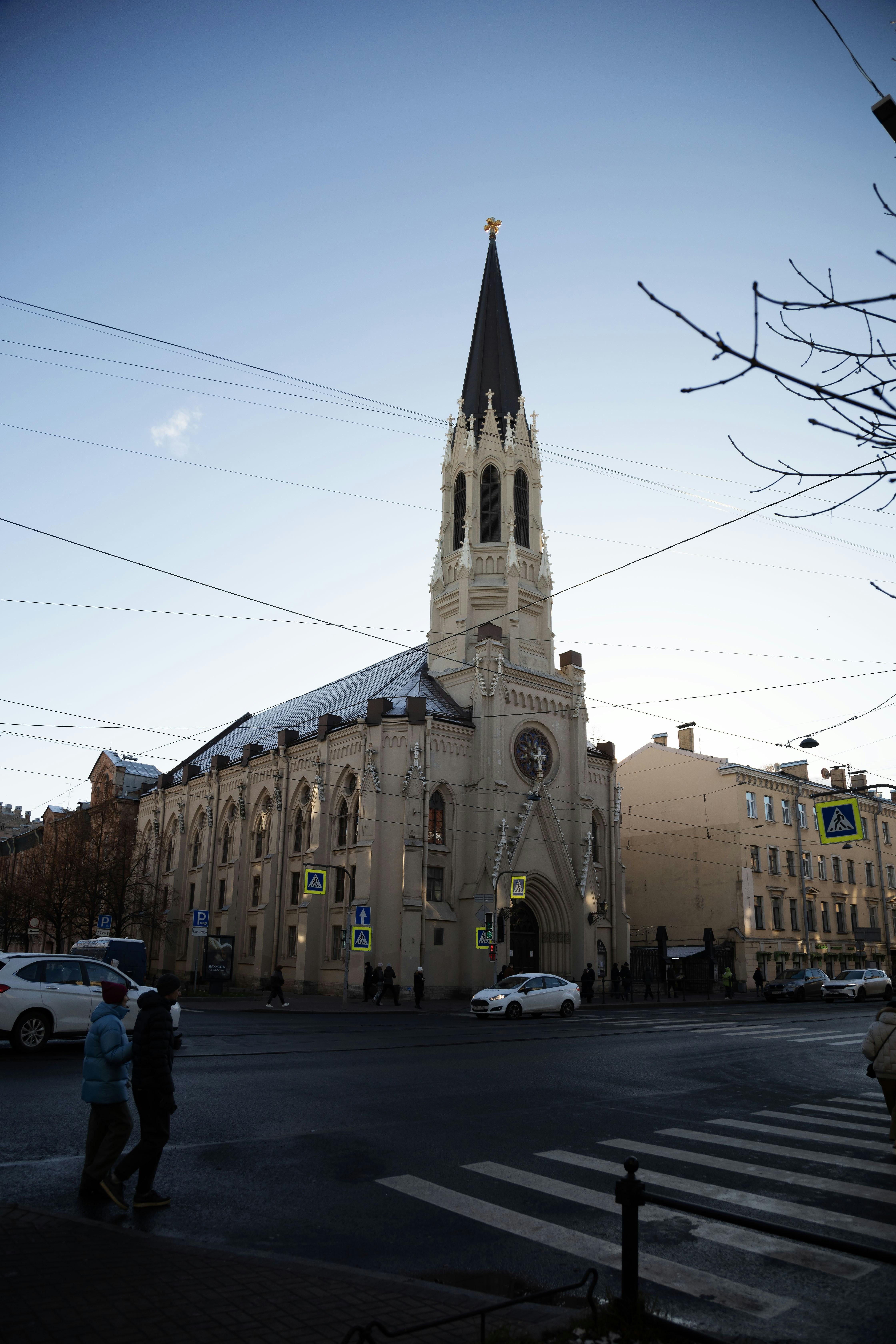 Towering Spire Against a Sky-Blue City: Gothic Revival on a Quiet Street