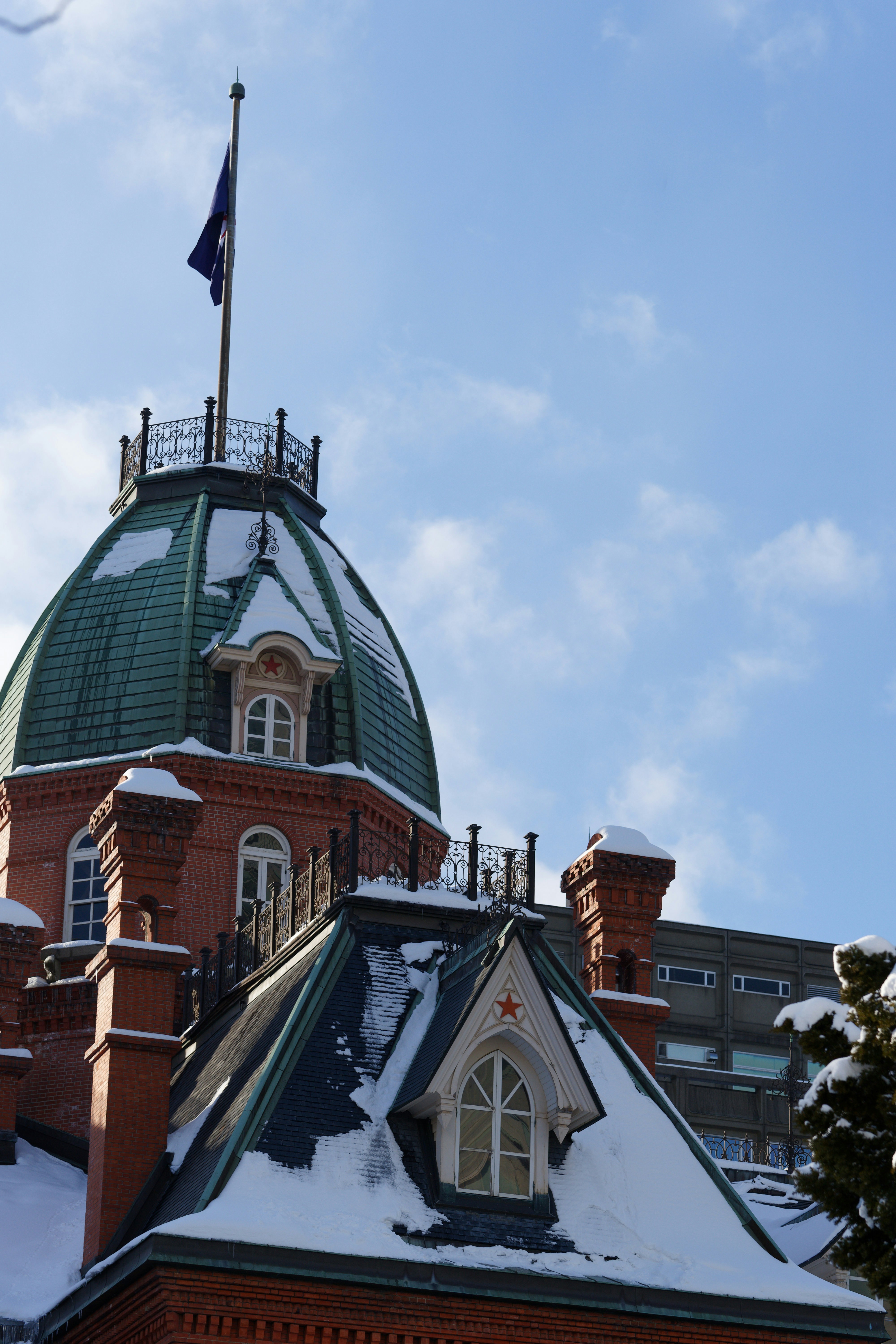 Historic building with snow-covered roof and flag