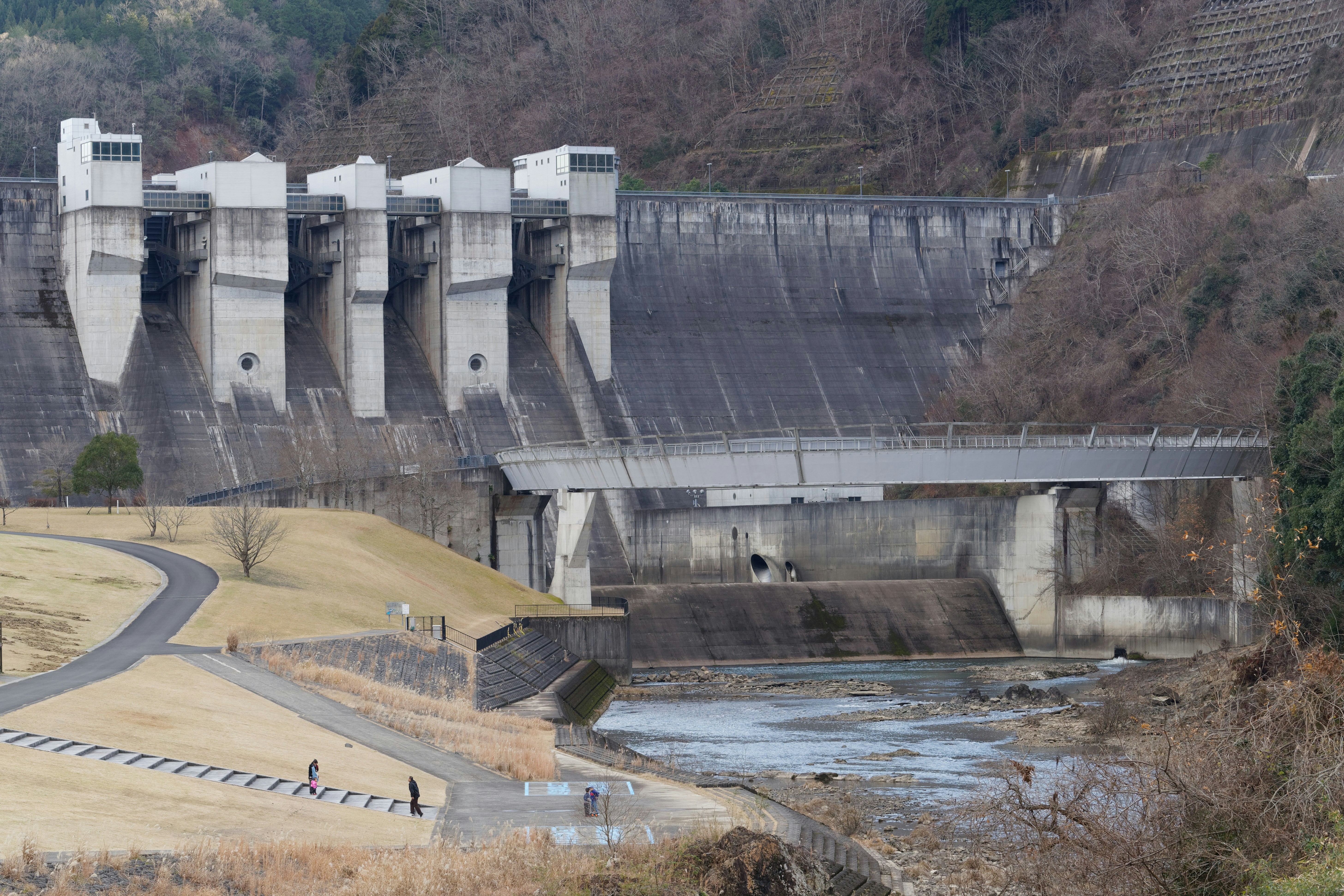 Concrete dam with water flowing through spillways