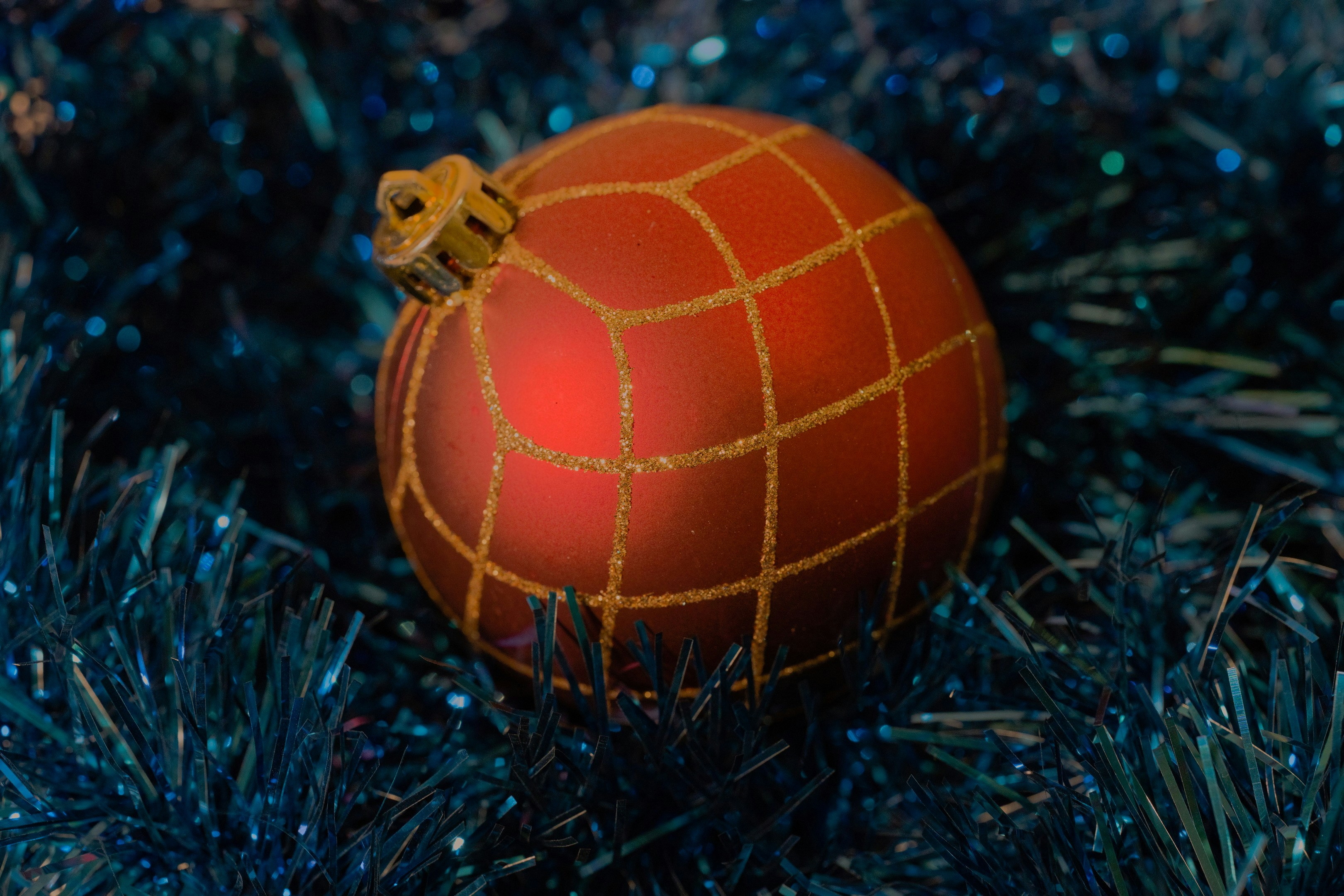Glowgrid Ornament: An Orange Bauble Framed by Electric Blue Tinsel