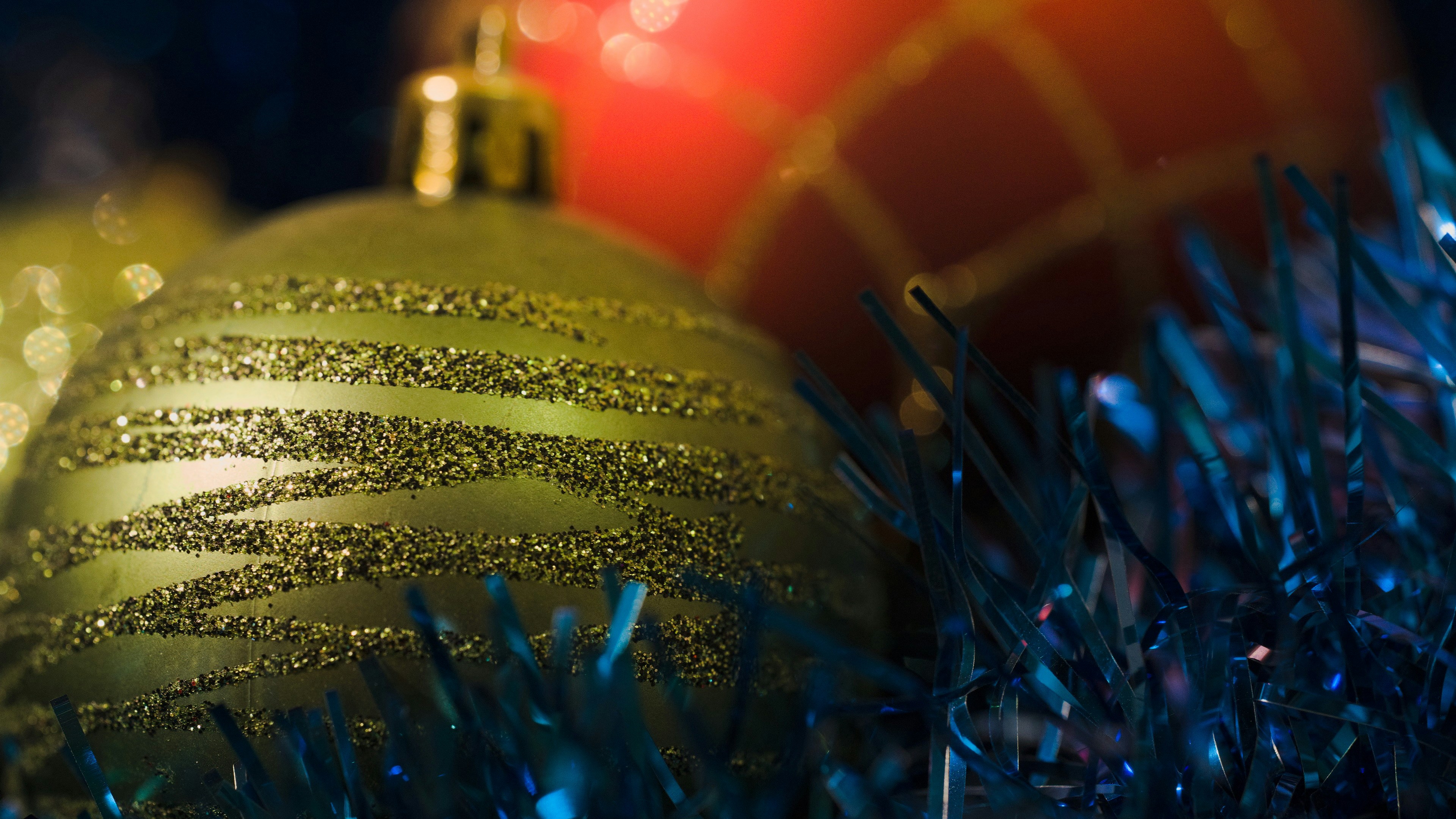 Glittering Gold Bauble Framed by Blue Tinsel in a Holiday Macro