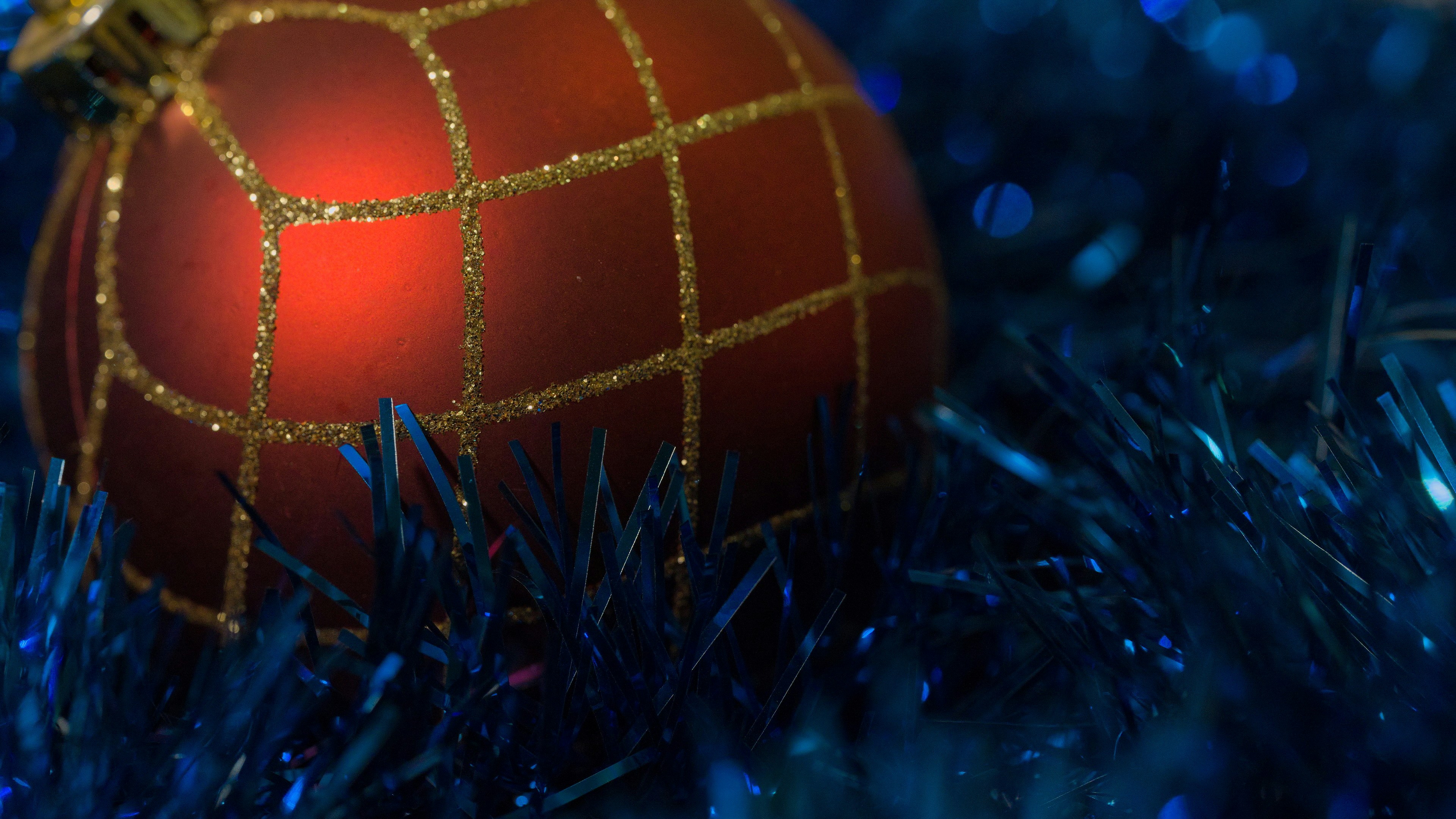 Crimson Ornament Framed by Electric Blue Tinsel Under Velvet Darkness