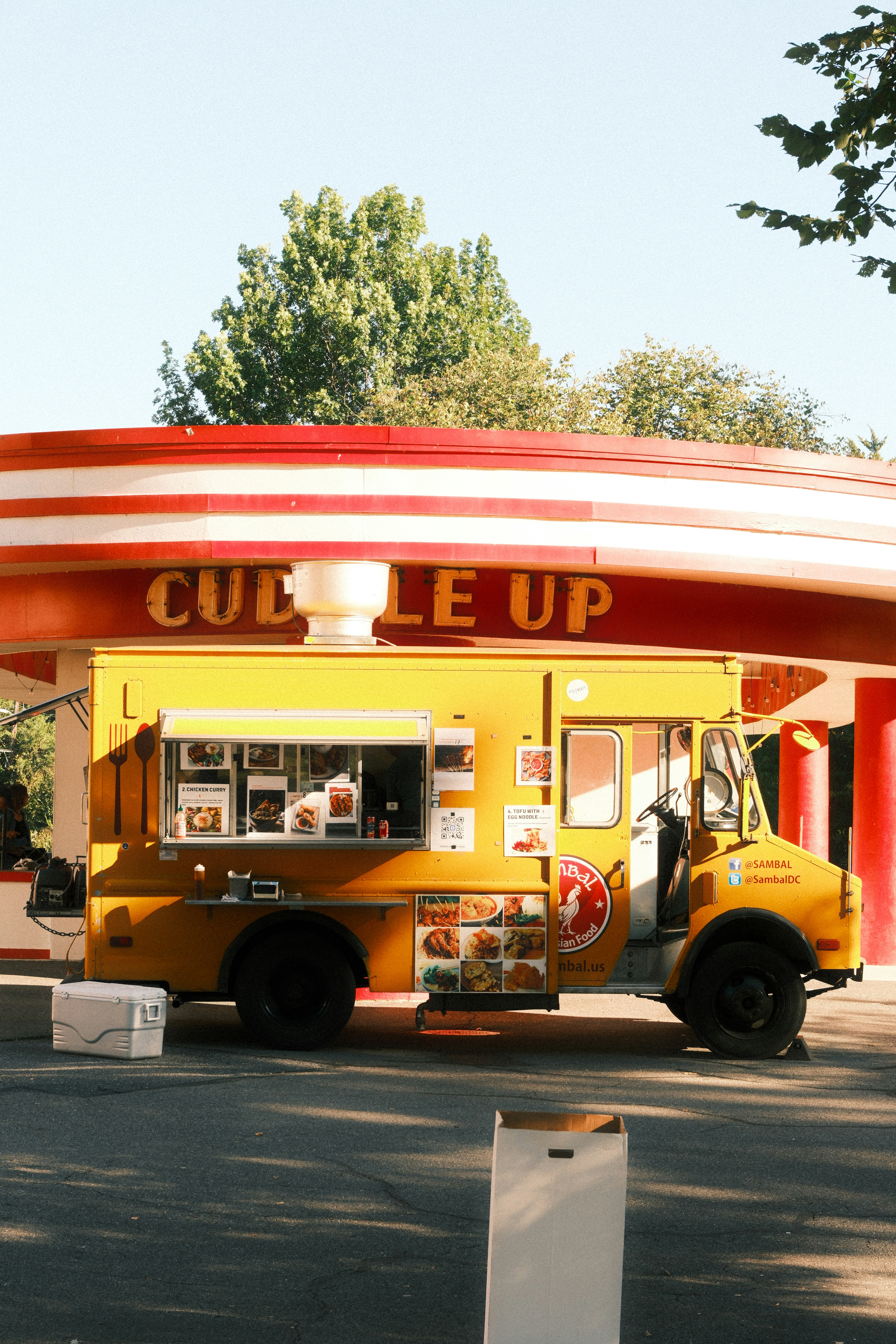 Sunlit Yellow Food Truck Under a Retro Red Canopy