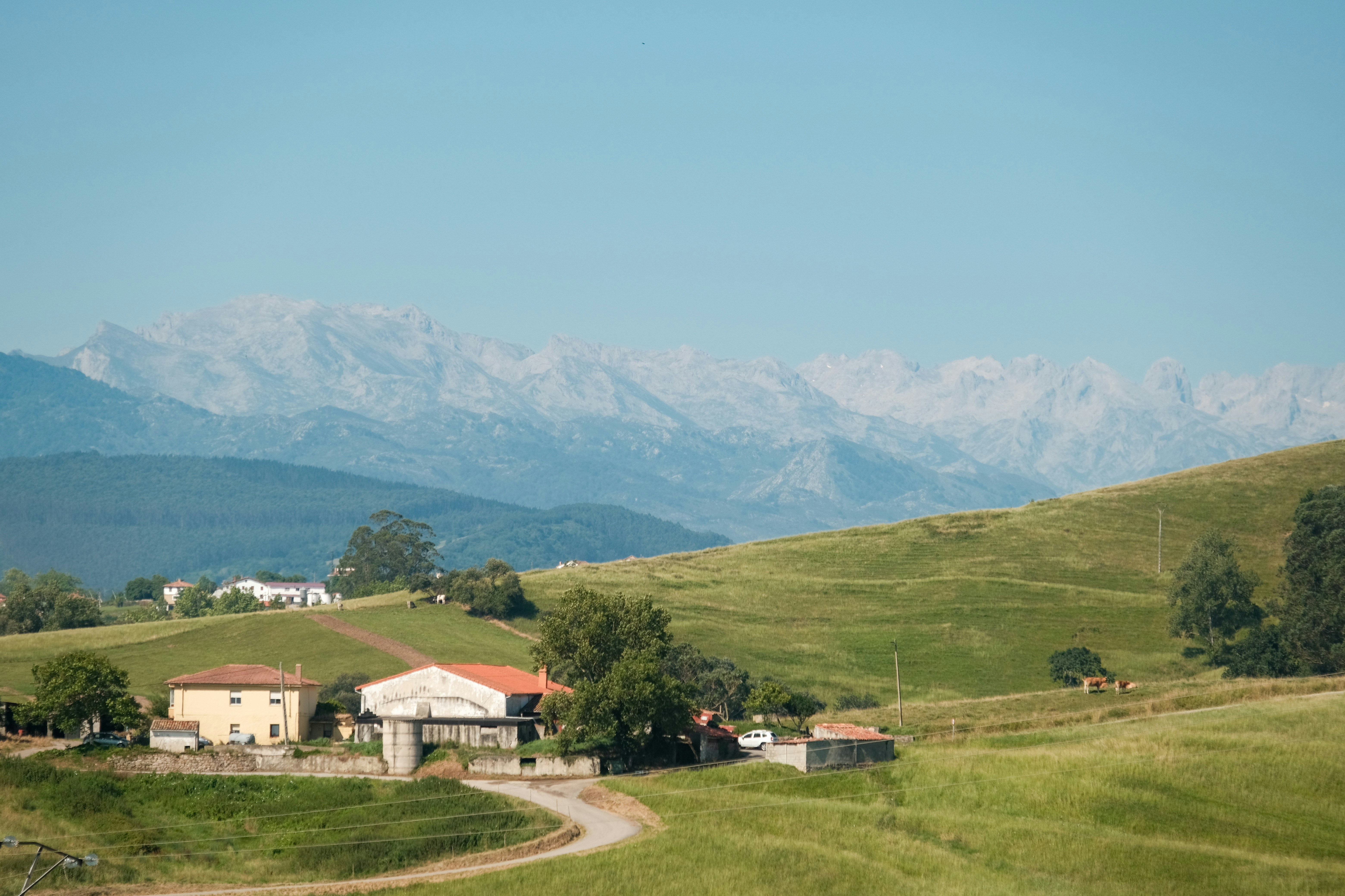 Snow-Kissed Peaks Behind a Tranquil Farmstead