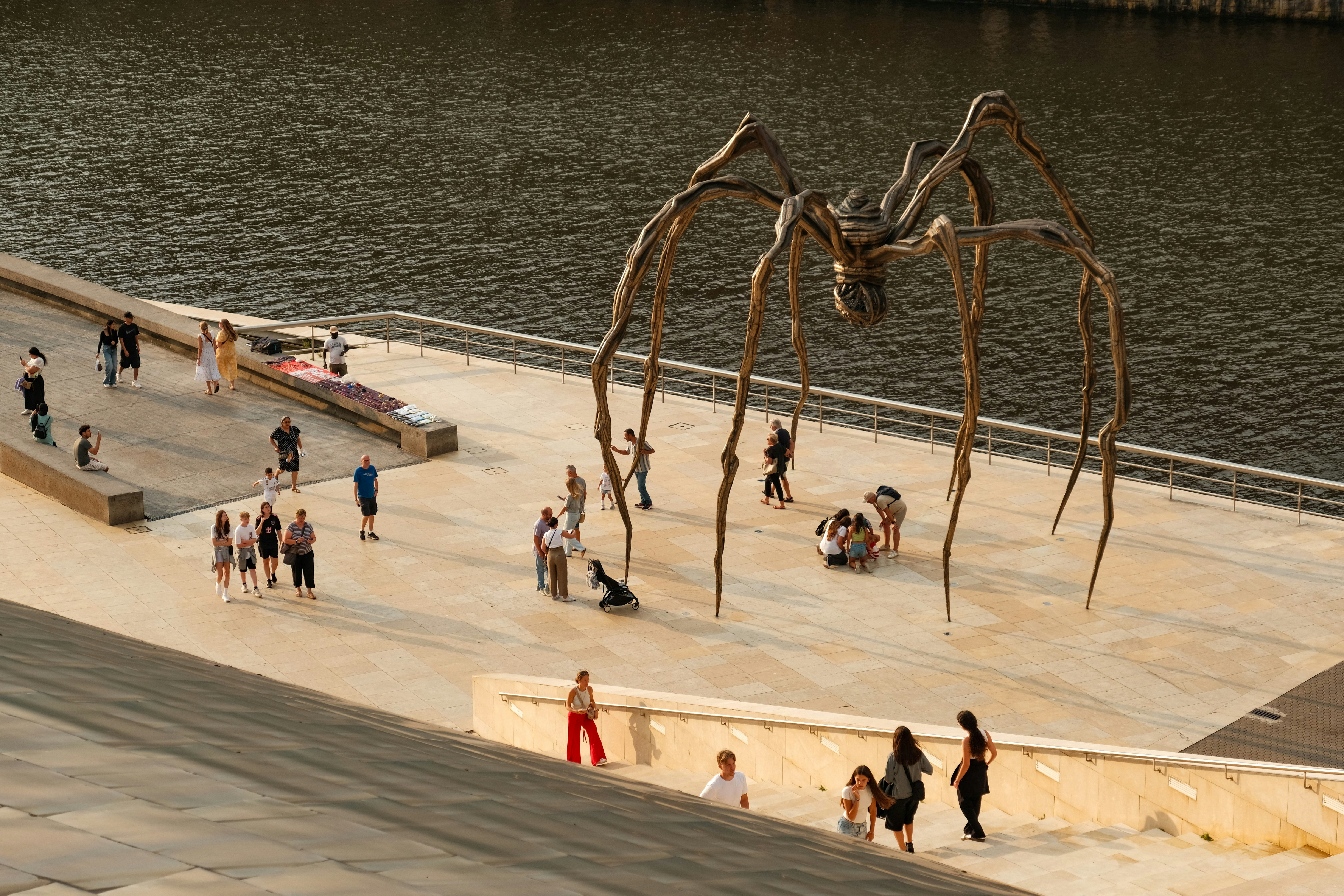 Riverside Sentinel: The Giant Spider Overlooking a Sunlit Plaza