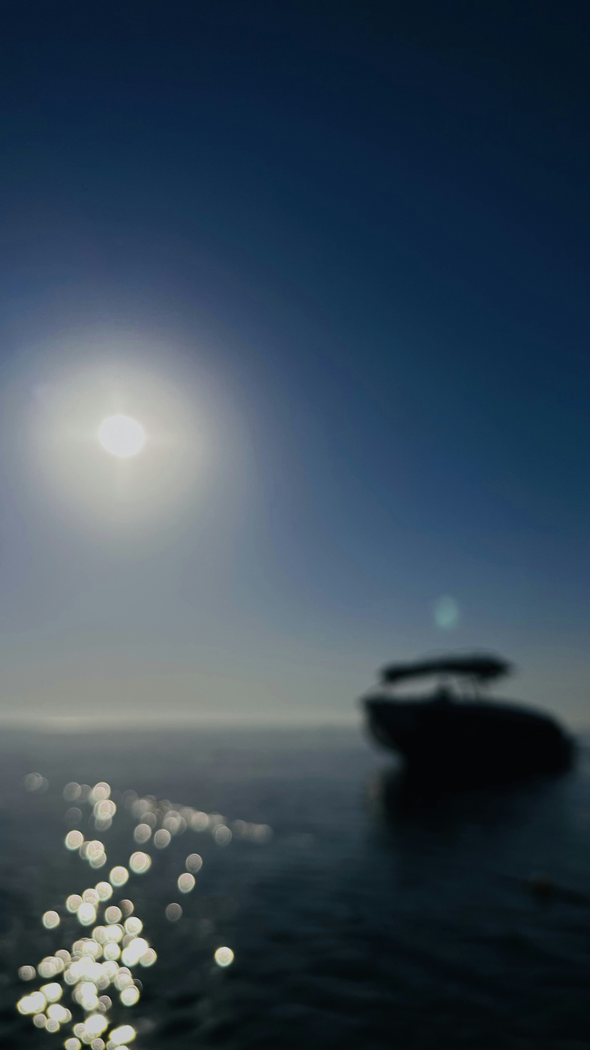 Sunlit Blur over the Sea: A Distant Boat in Soft Focus