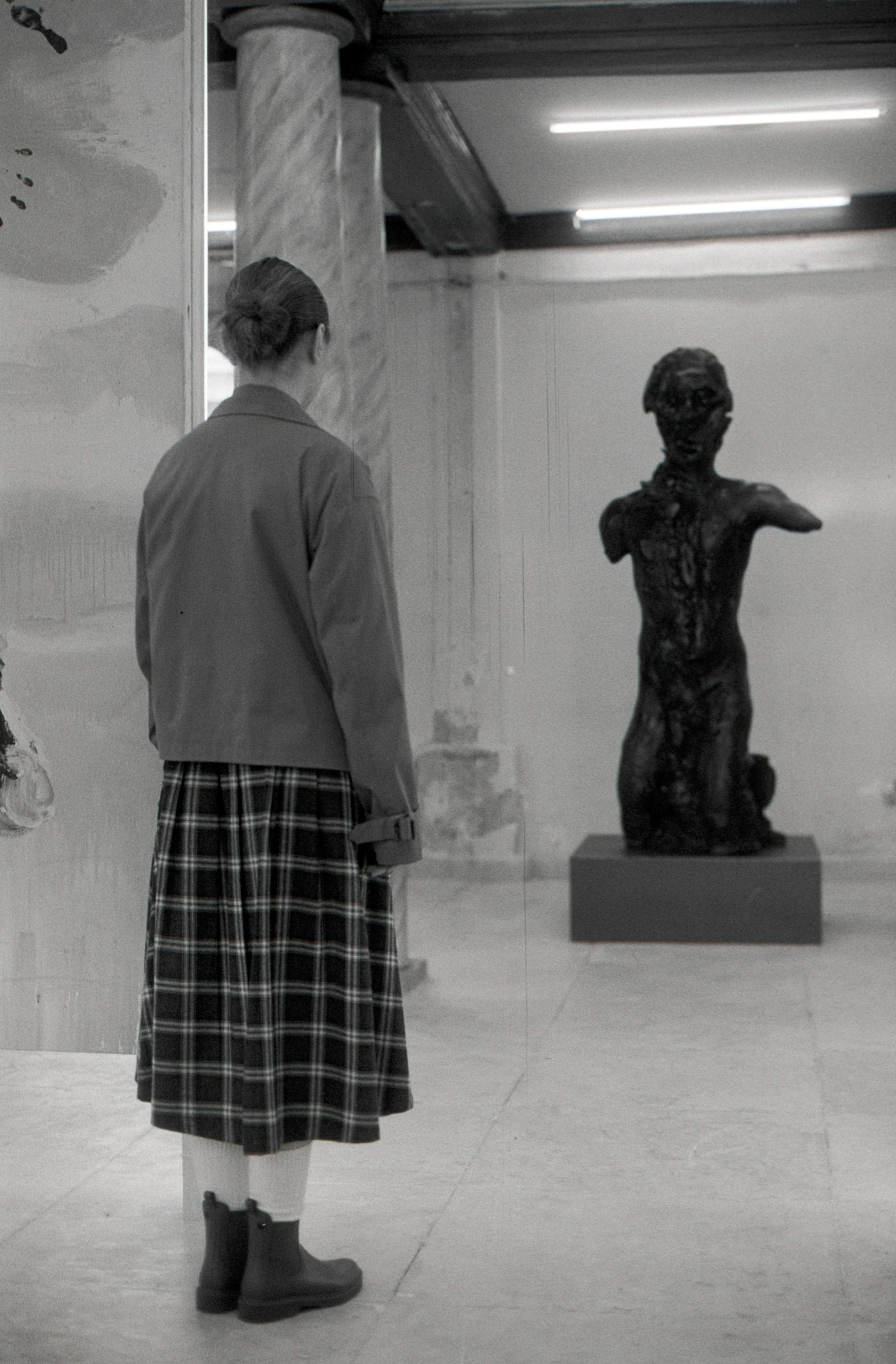 Person looking at a sculpture in a gallery.