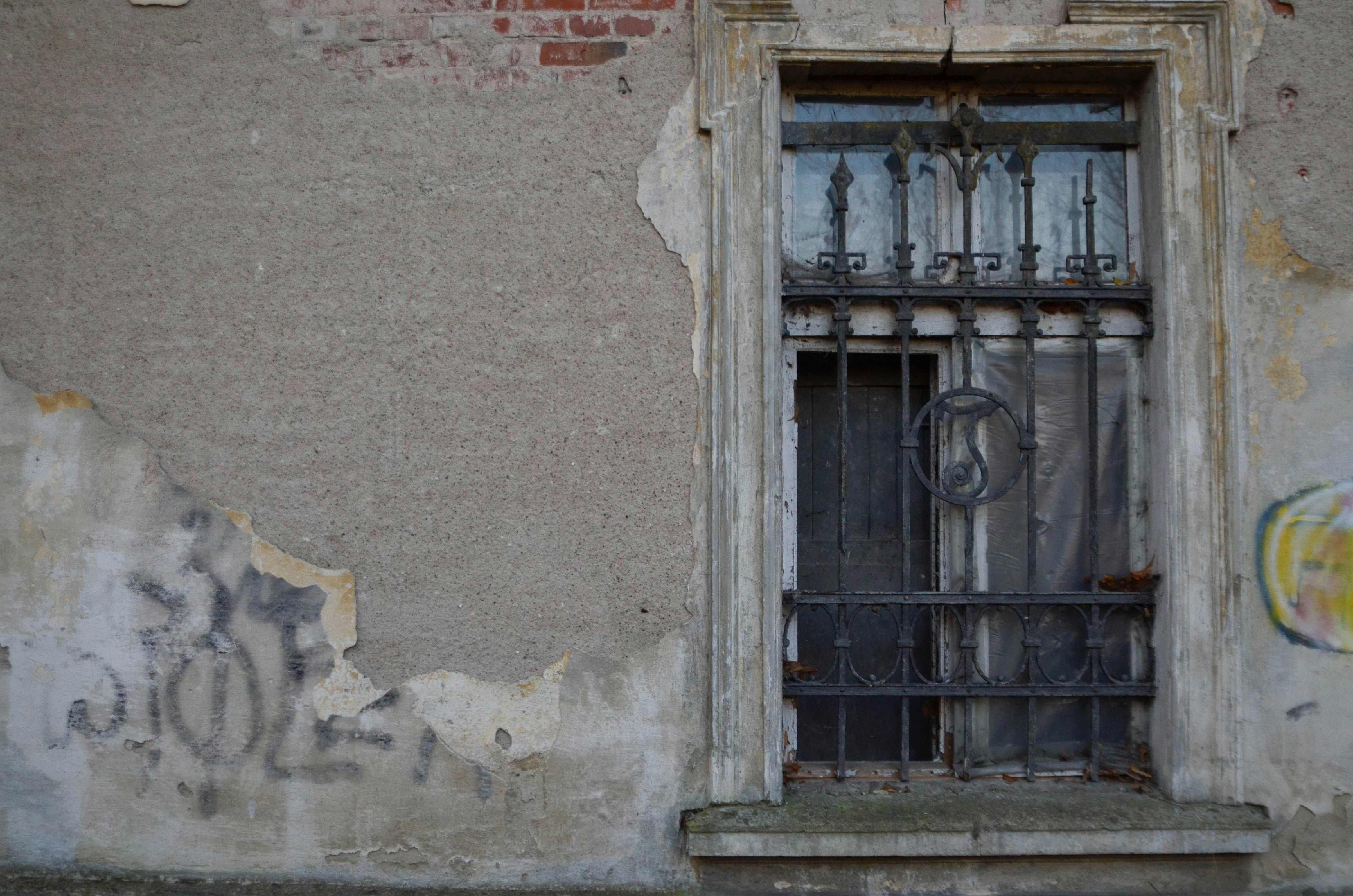 Barred Window and Weathered Facade: A Quiet Portrait of Urban Decay