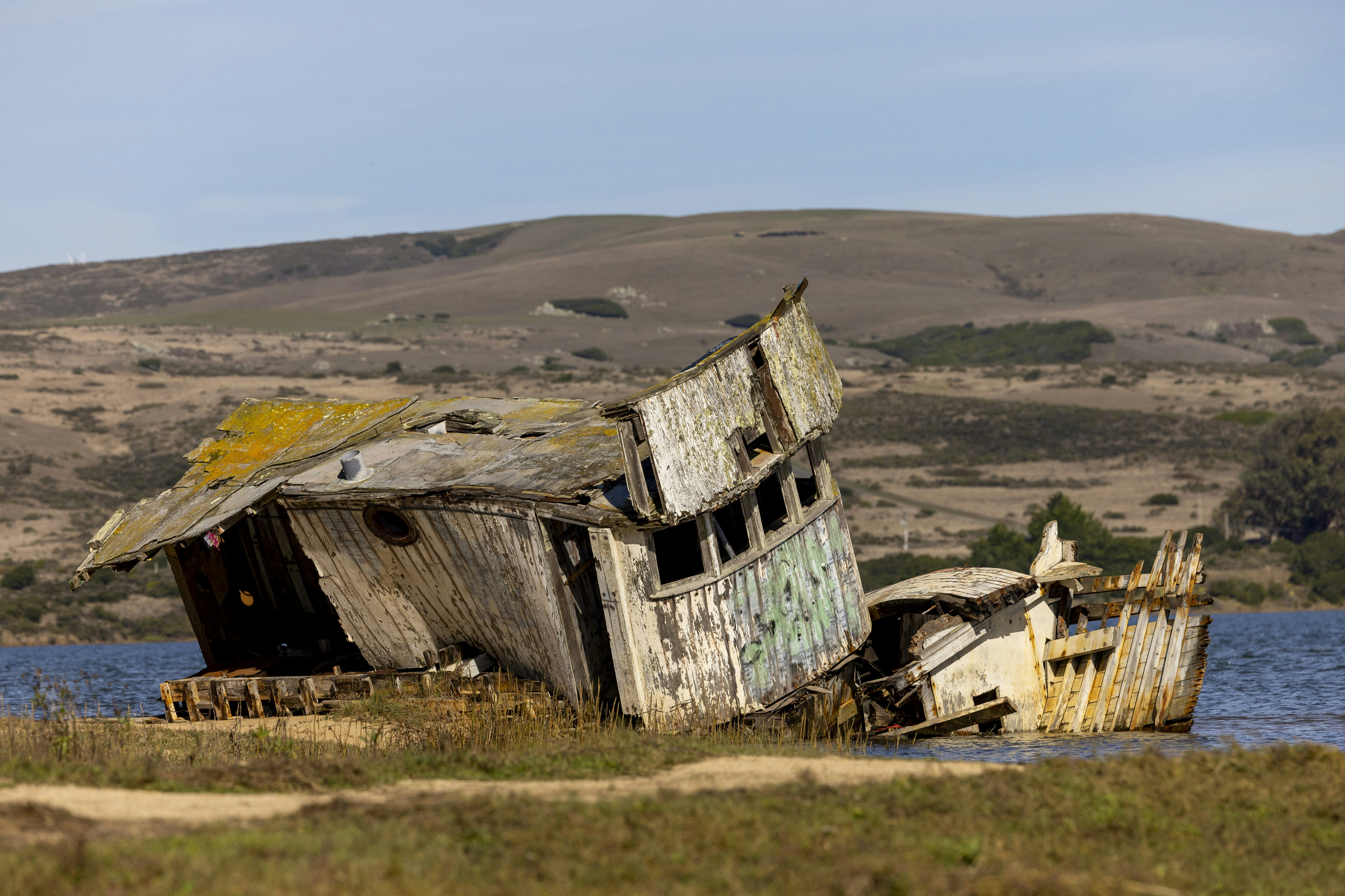 Tilted Timeworn Hull Resting by a Quiet Lake
