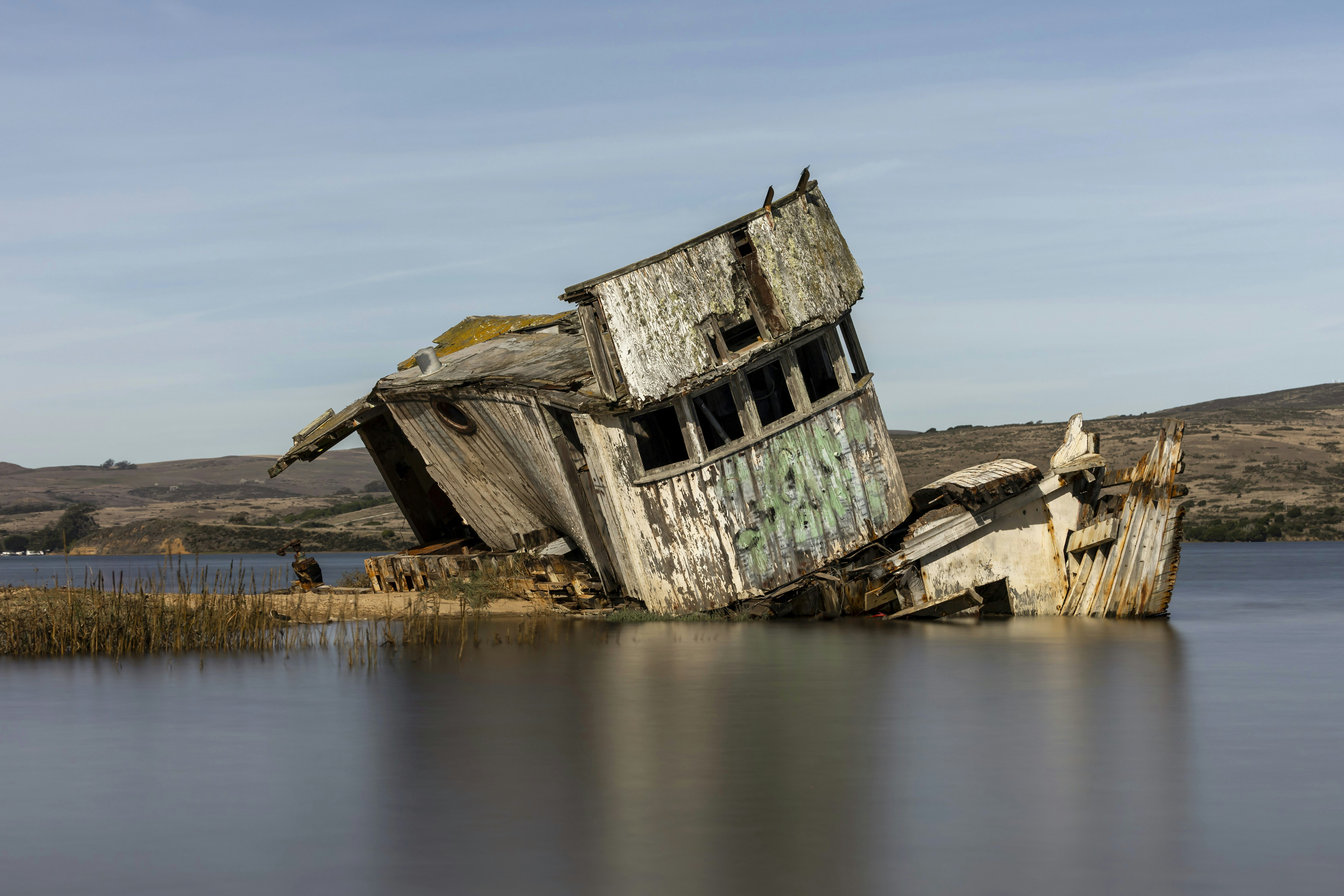Tilted Time Capsule: A Rusted Cabin Wreck Resting on a Glassy Lake